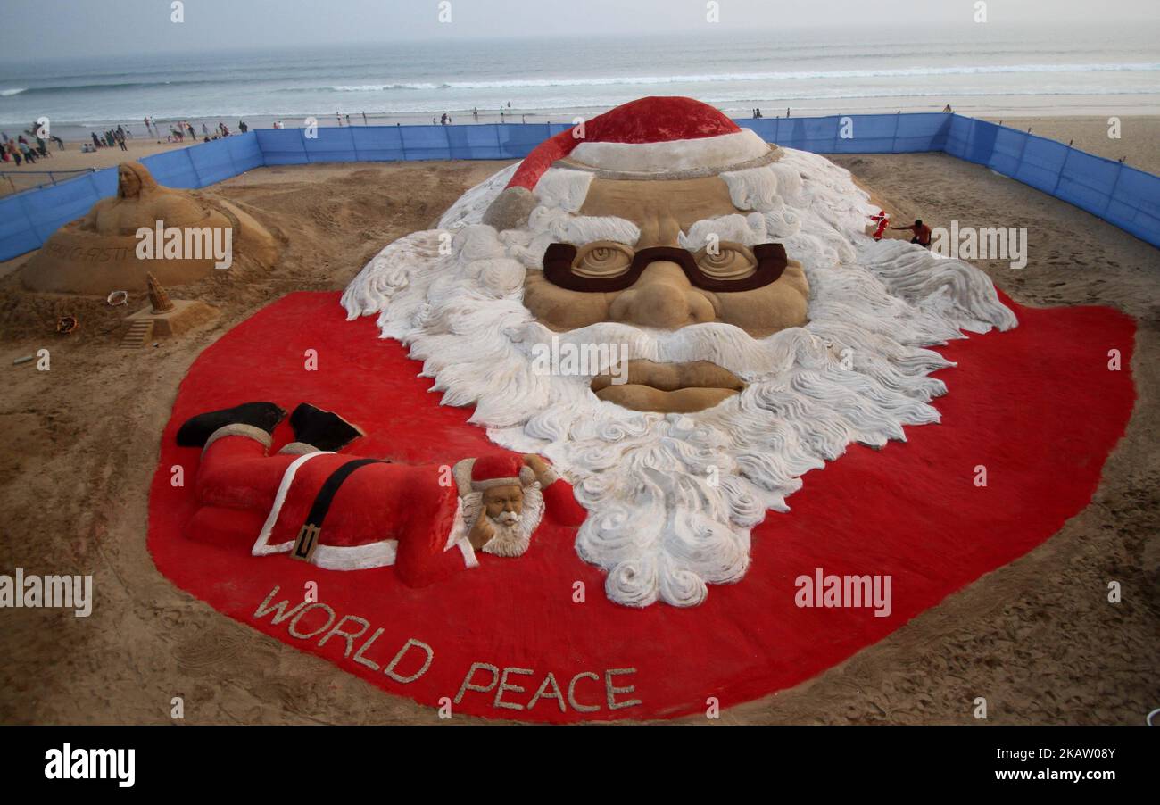 A sand portrait of Santa Claus is seen on the Bay of Bengal Sea's ...
