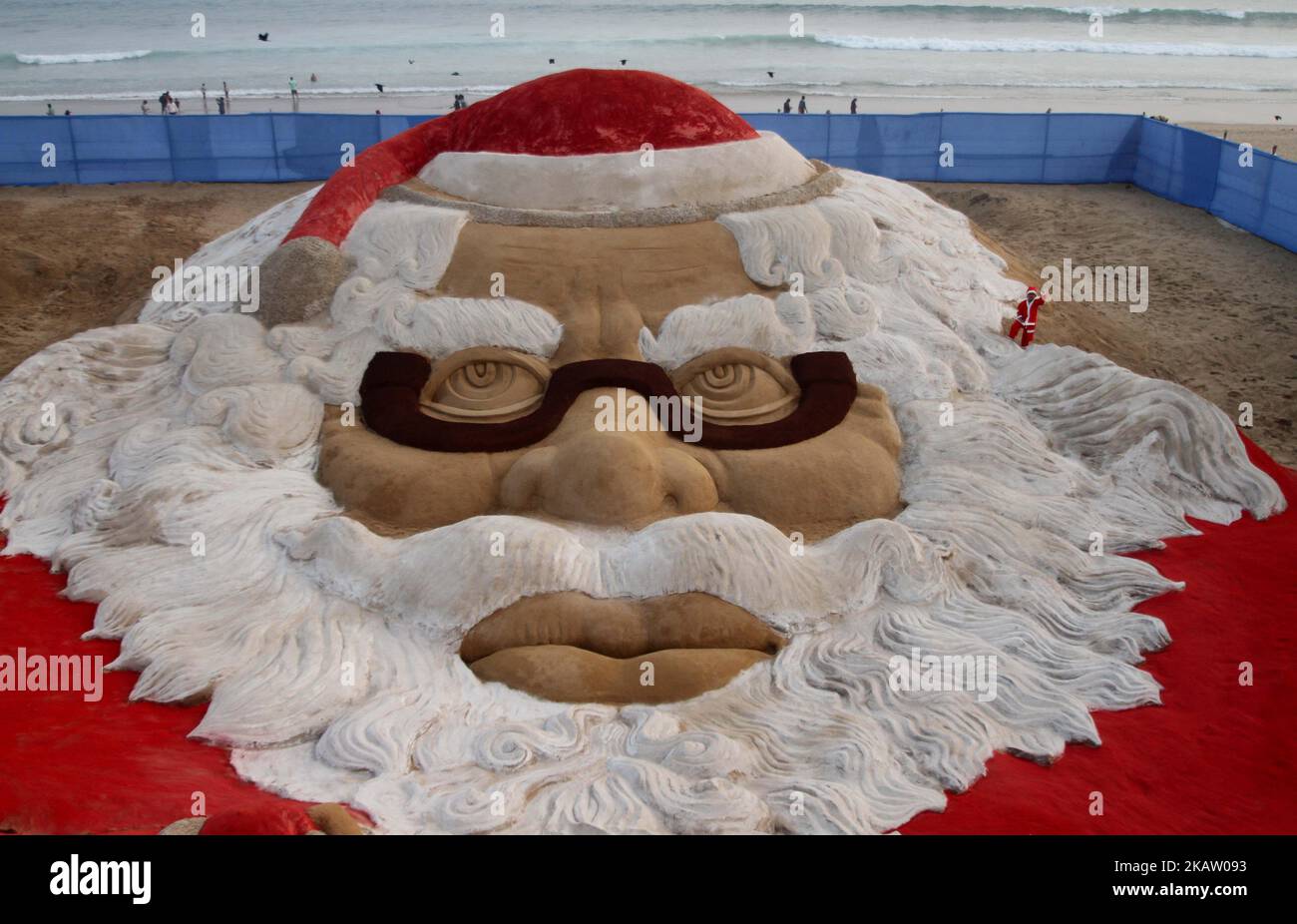A sand portrait of Santa Claus is seen on the Bay of Bengal Sea's ...