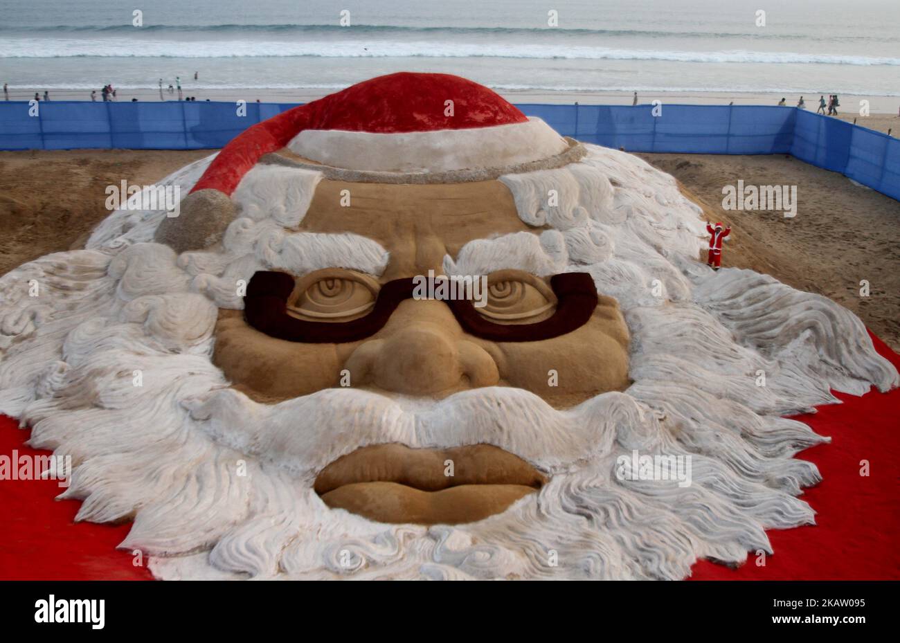 A sand portrait of Santa Claus is seen on the Bay of Bengal Sea's ...