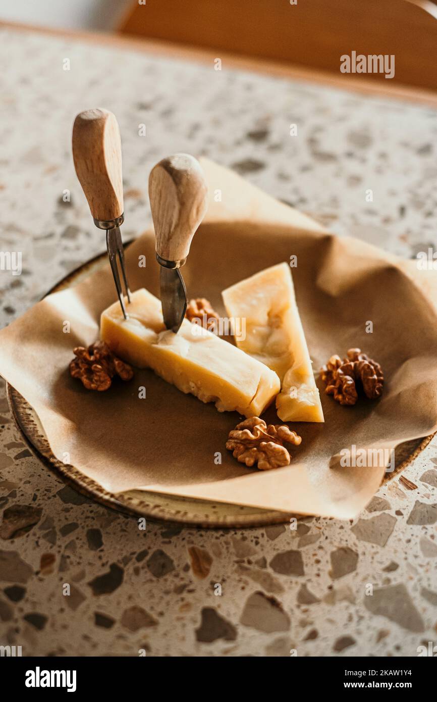 A vertical shot of a plate with cheese slices and walnuts Stock Photo ...