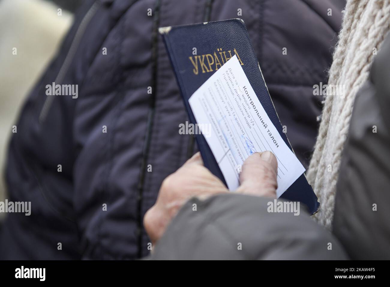 woman holds a Passport and control ticket Checkpoint "Hnutove" in ...