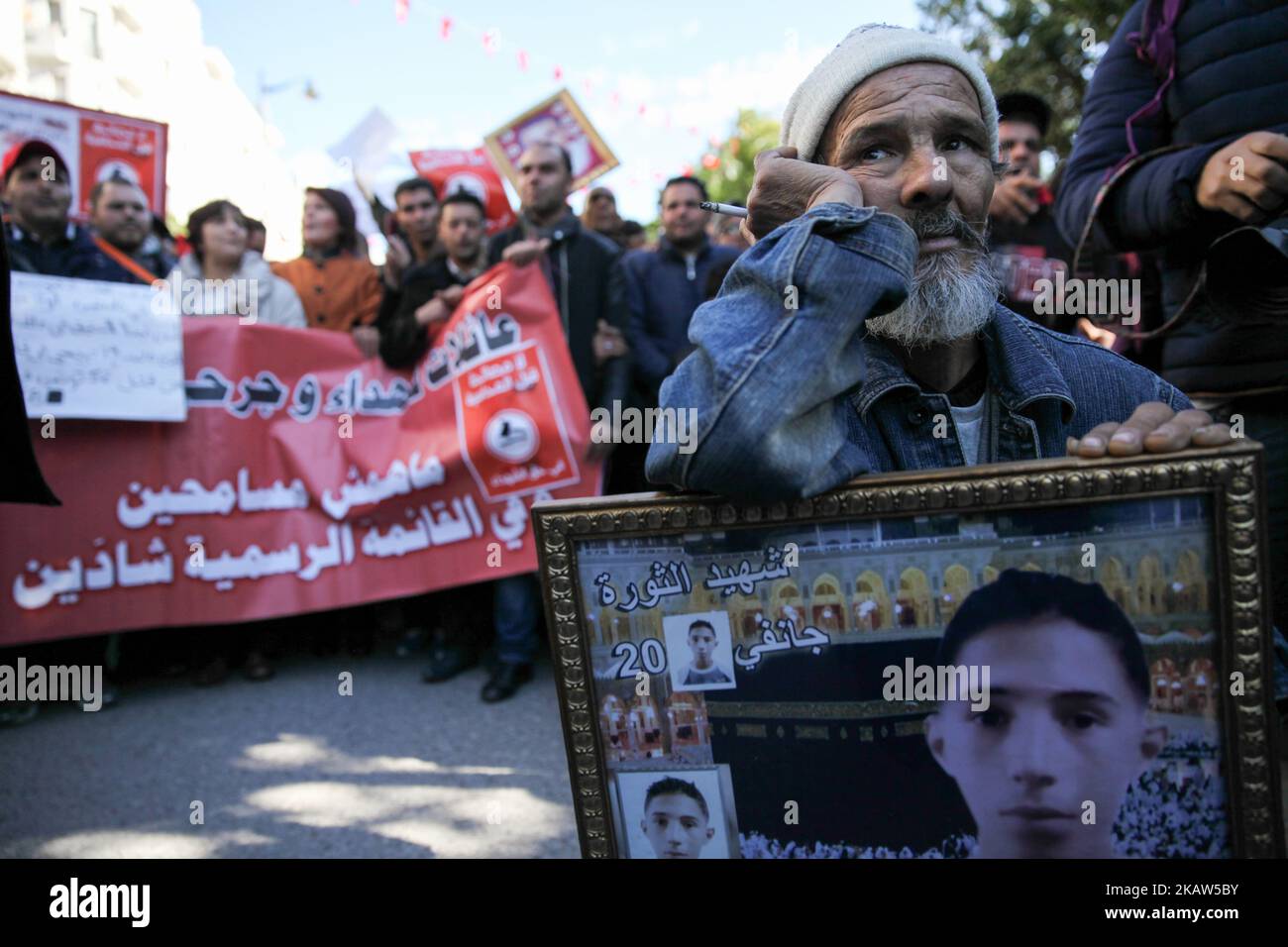 A father holds a portrait of his son killed during the clashes of the ...