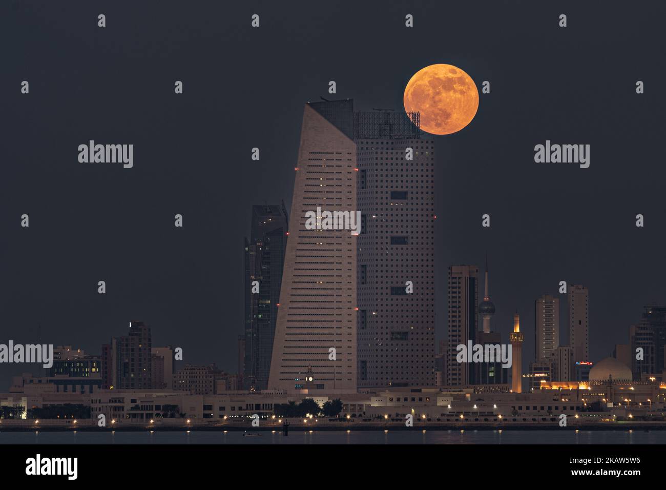 A beautiful shot of Kuwait City skyline with a full moon in Kuwait ...