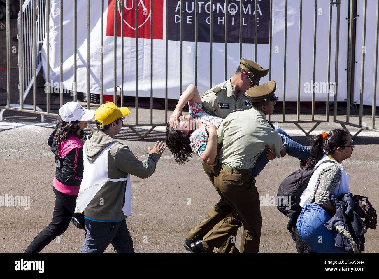 Police leads a fainting woman during Pope Francis gives a mass called ...