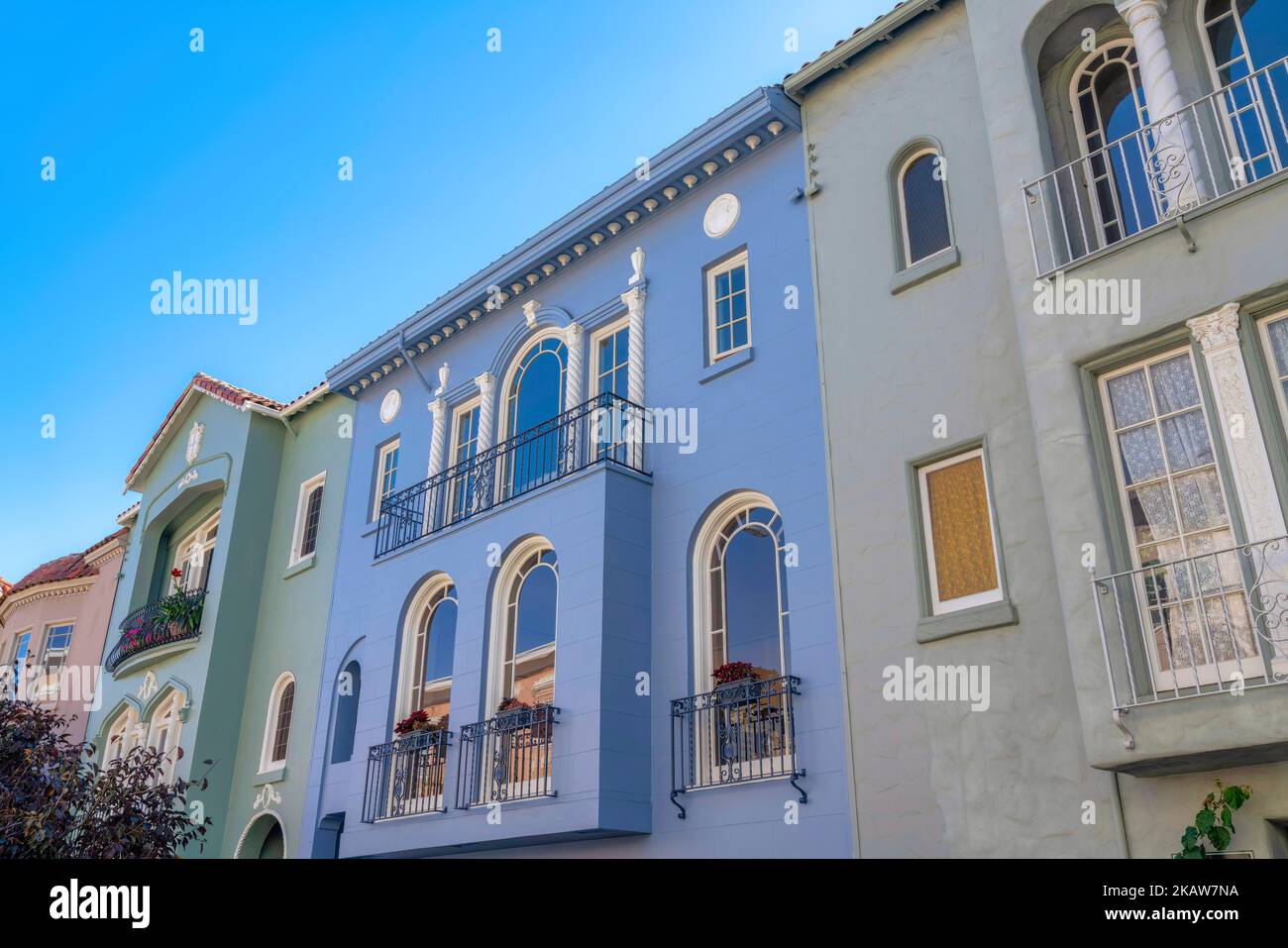 Adjacent italianate homes with decorative pillars and arched windows in ...