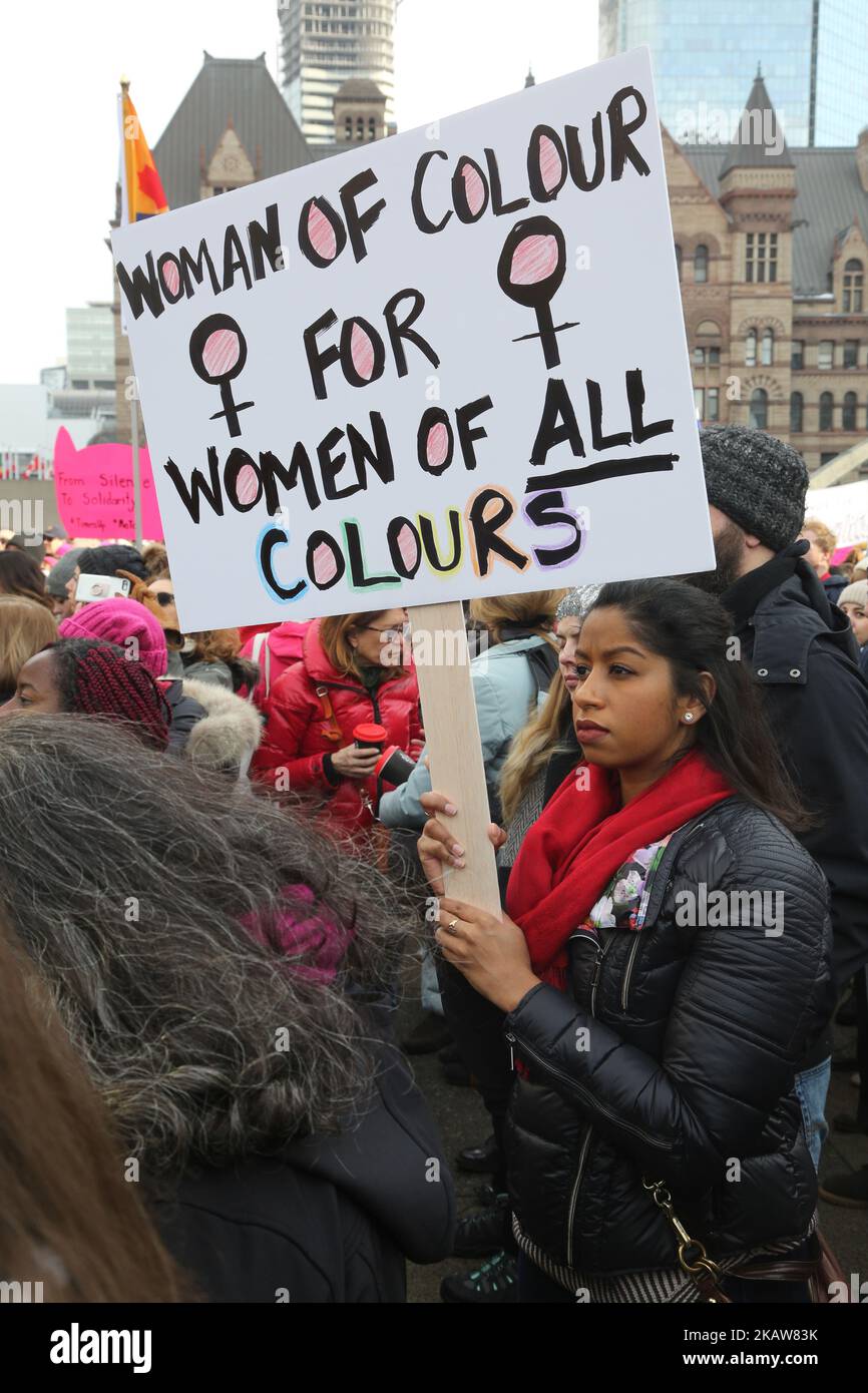 Woman holding a sign saying 'Woman of Color for Women of all Colors' as ...