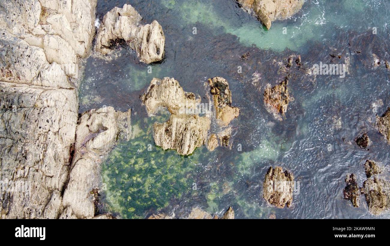 A lot of boulders in the sea water, top view. Coastal cliffs of the ...