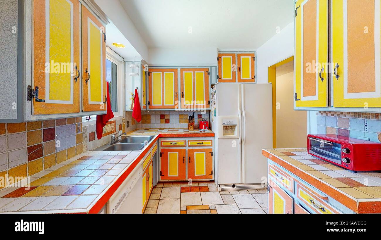 A colorful orange and yellow kitchen design with fridge, red Oven Grill ...