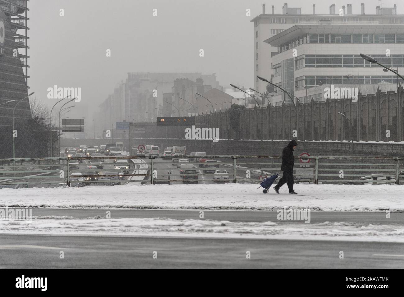 A man walks under snow falling again in Paris, France, on 9 February ...