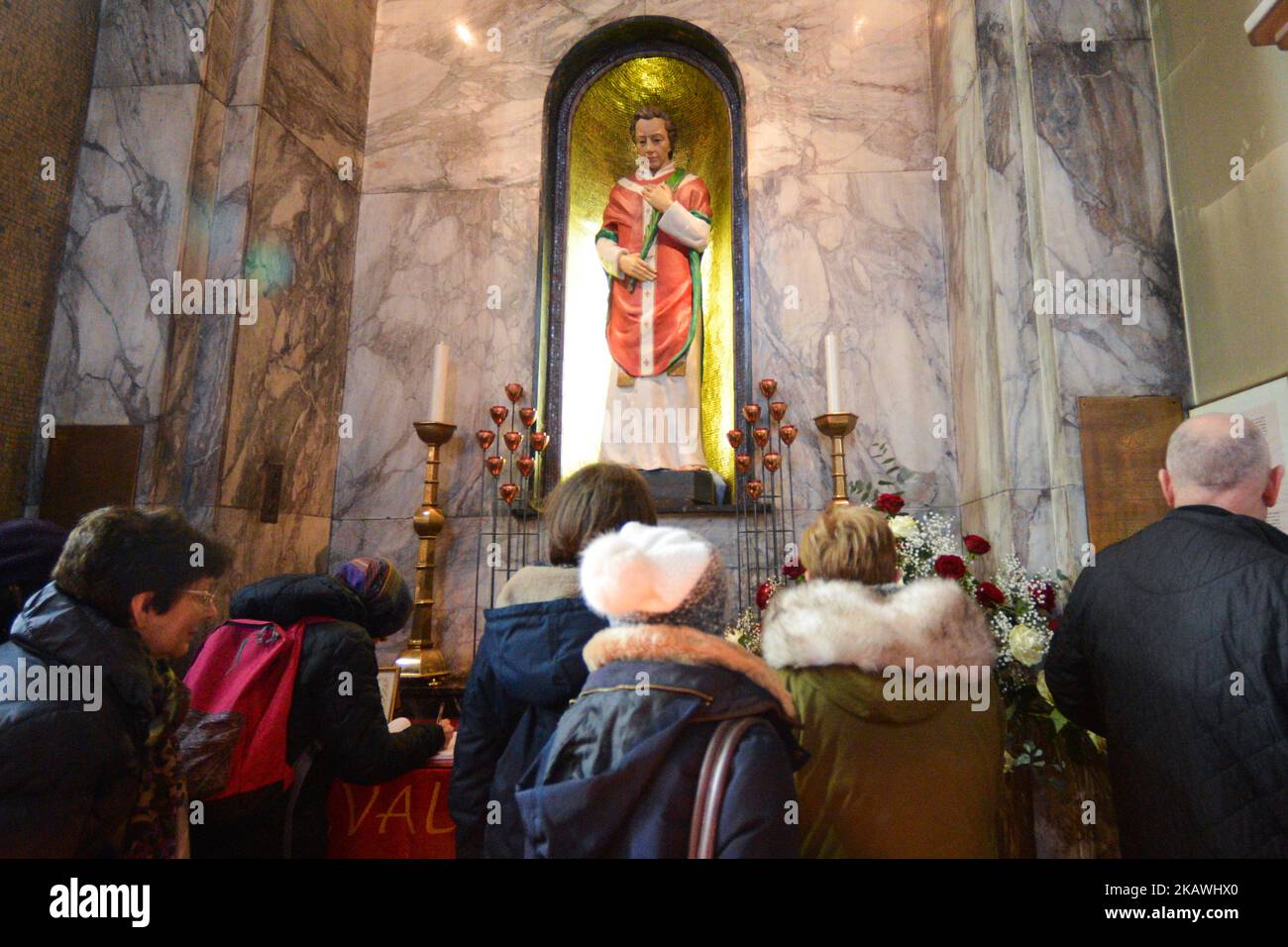 A view of the crowd at the chapel with the statue of patron saint of ...