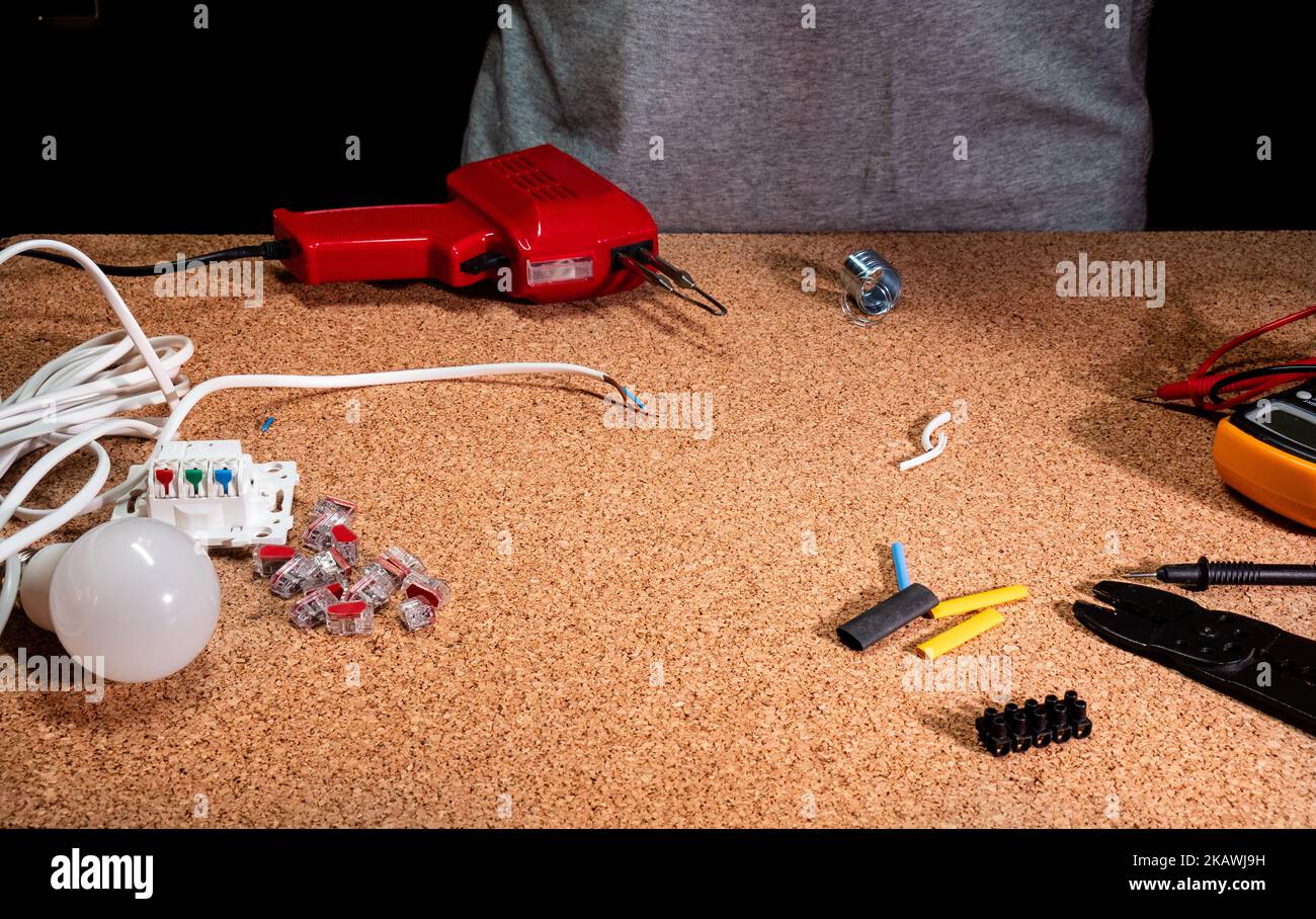 soldering - connecting wires with tin and soldering iron, workshop, in the background electrical ...