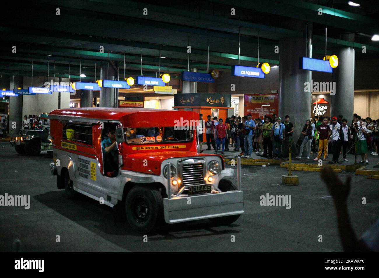 A jeepney filled with passengers leaves a loading bay in Manila ...
