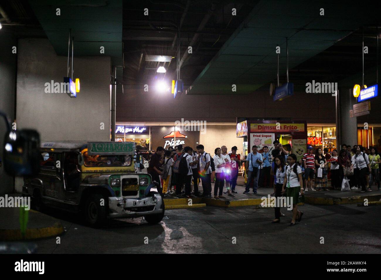 A jeepney stands idle, as commuters fall in line at a loading bay in ...