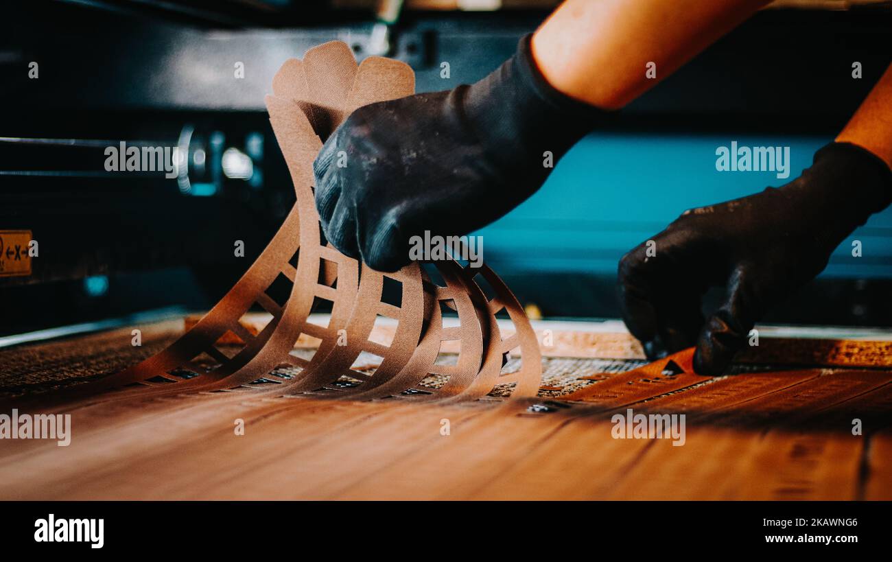 A worker picking up material from laser cut machine Stock Photo - Alamy