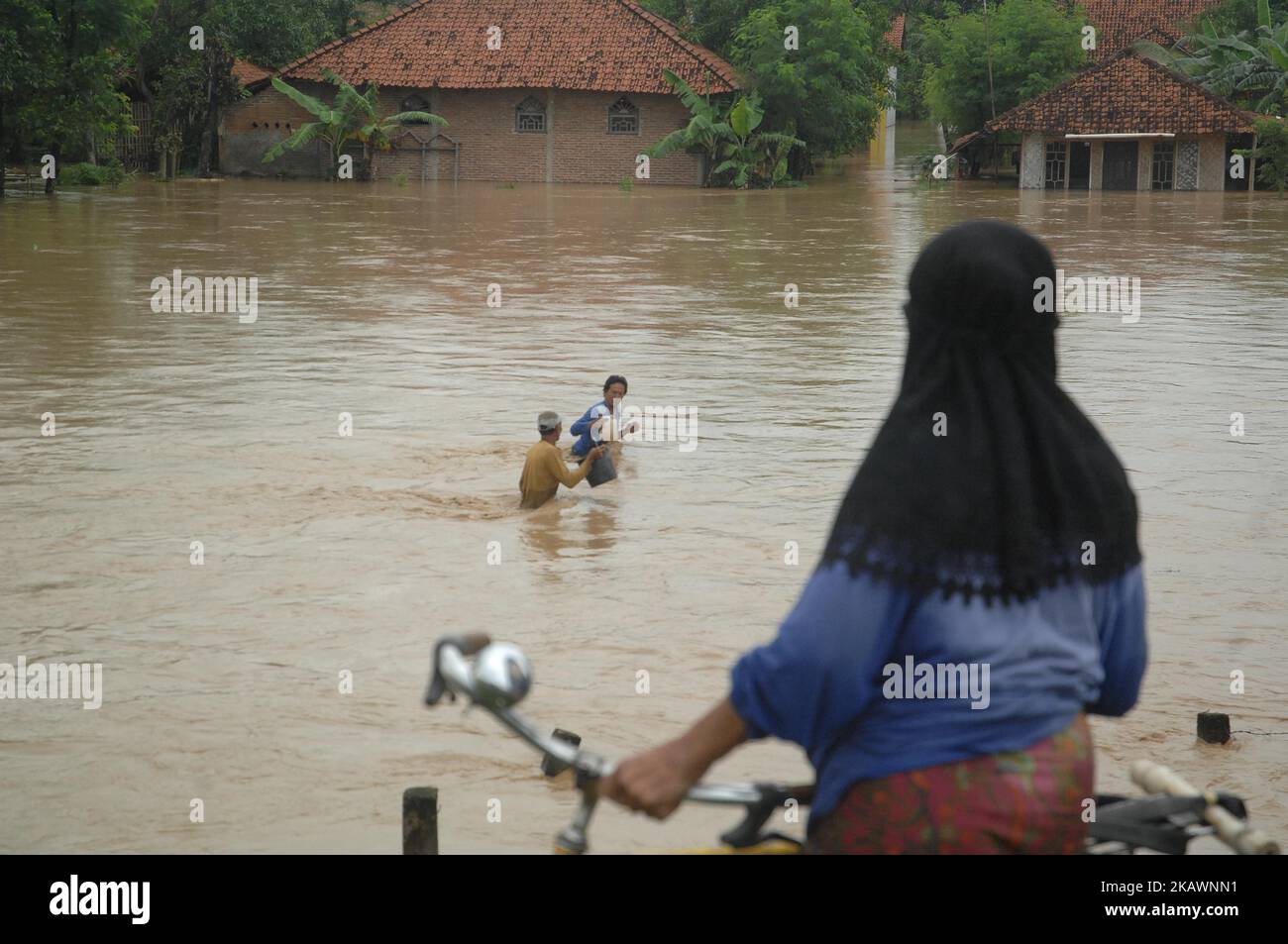 Residents cross the flood that struck the village of Danareja, Brebes, Central Java In February ...