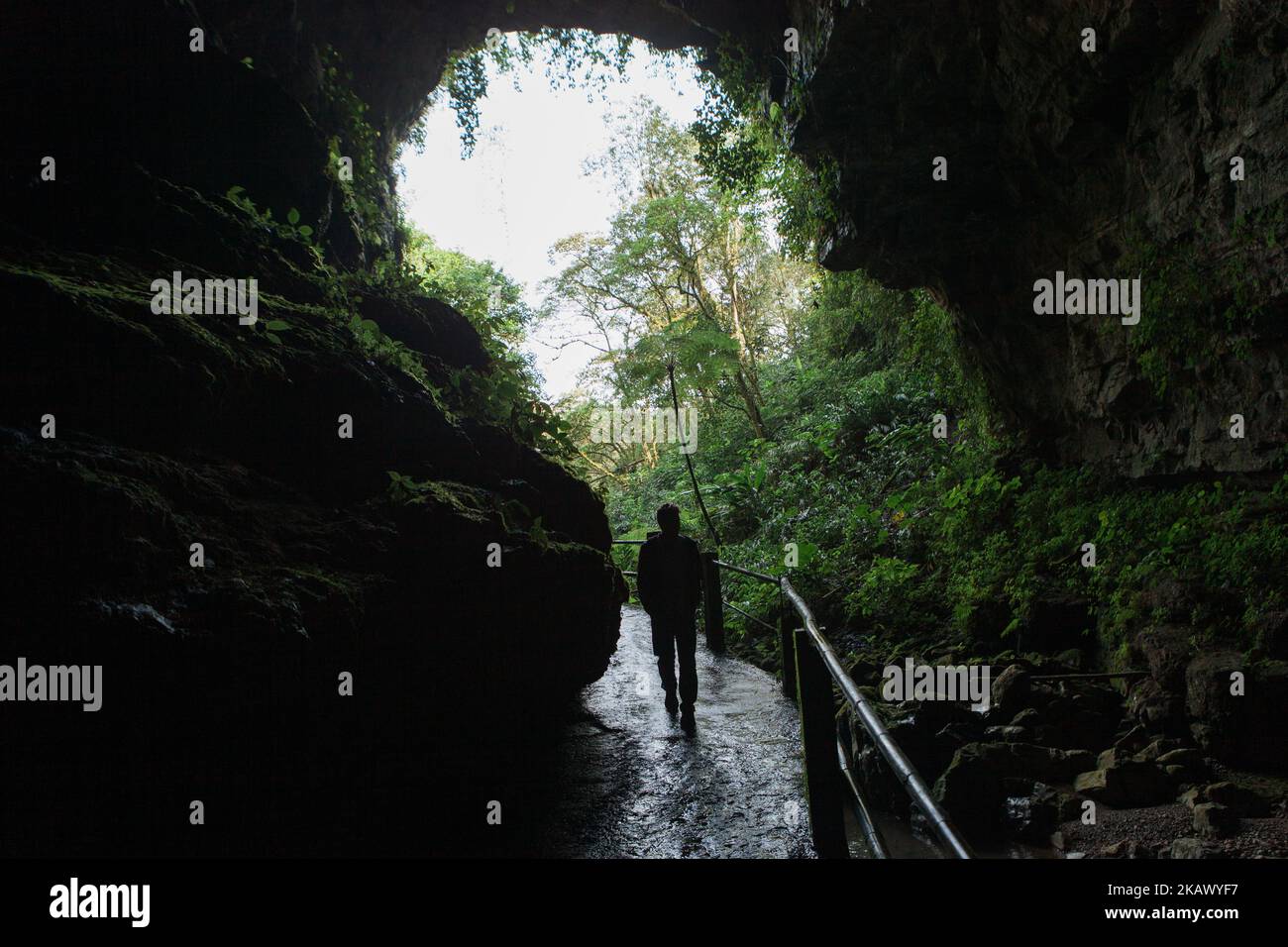 A silhouette of man walking out of dark cave Stock Photo - Alamy