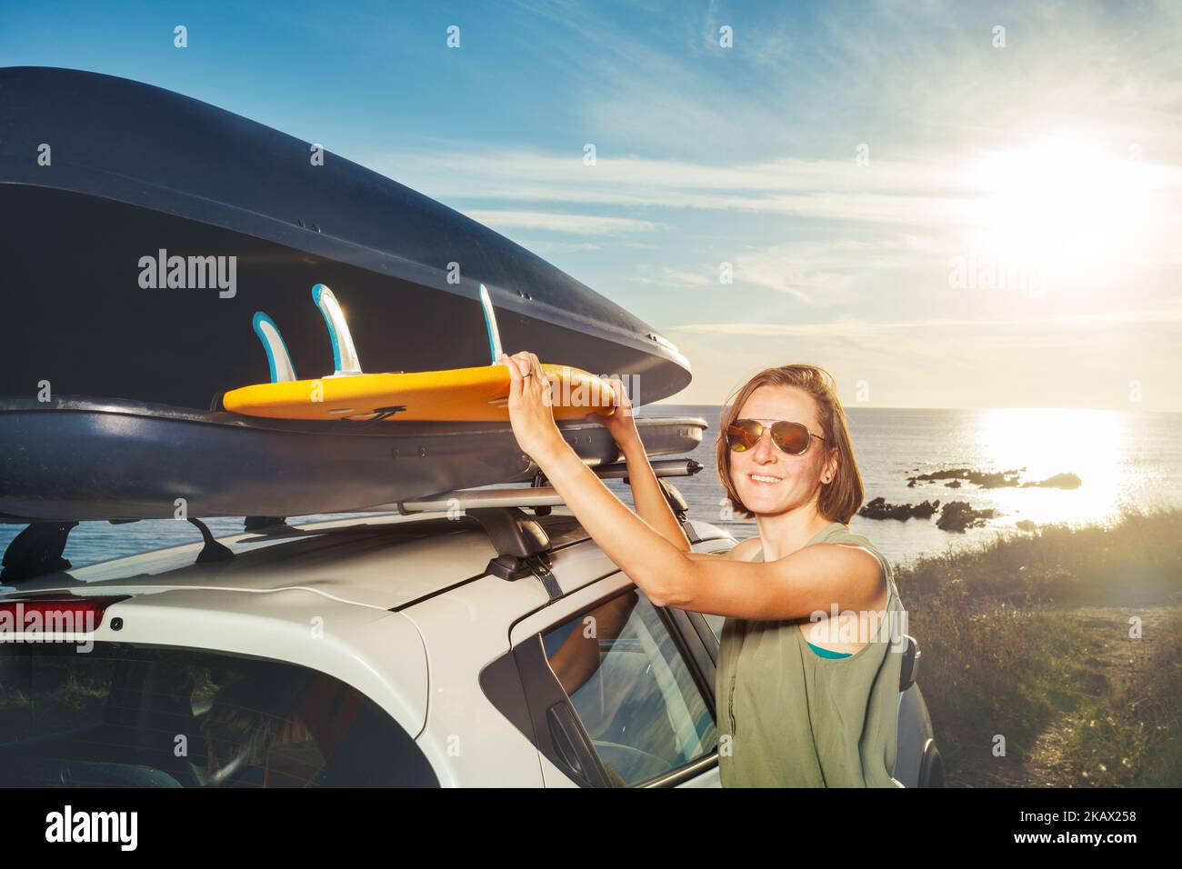 Unloading surfboard from car on surfing sunset spot Stock Photo - Alamy