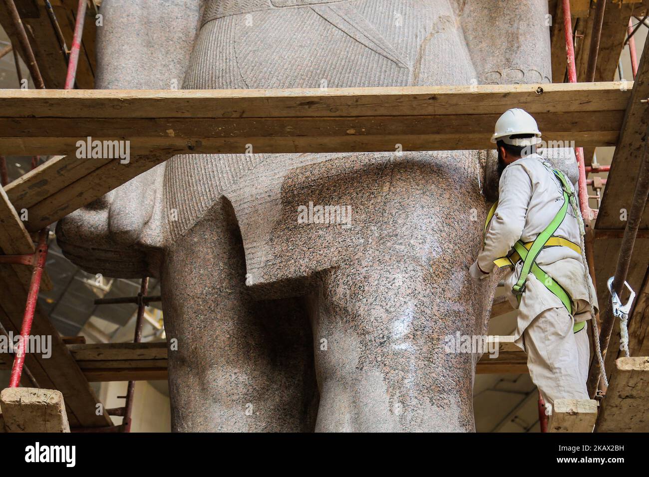 Egyptian workers restore a giant granite statue of the ancient Egyptian ...