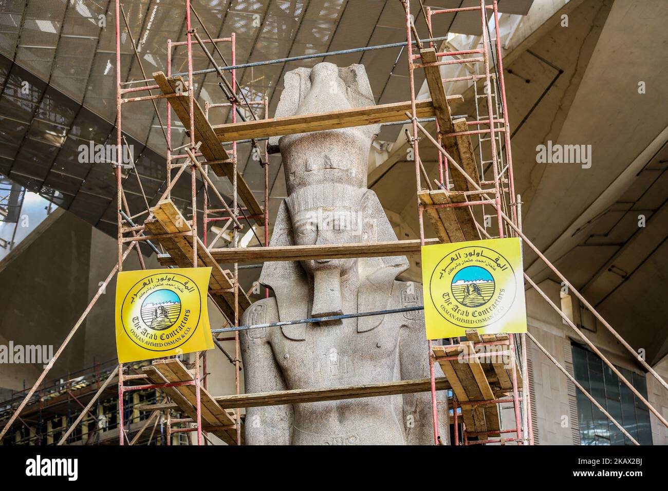 Egyptian workers restore a giant granite statue of the ancient Egyptian ...