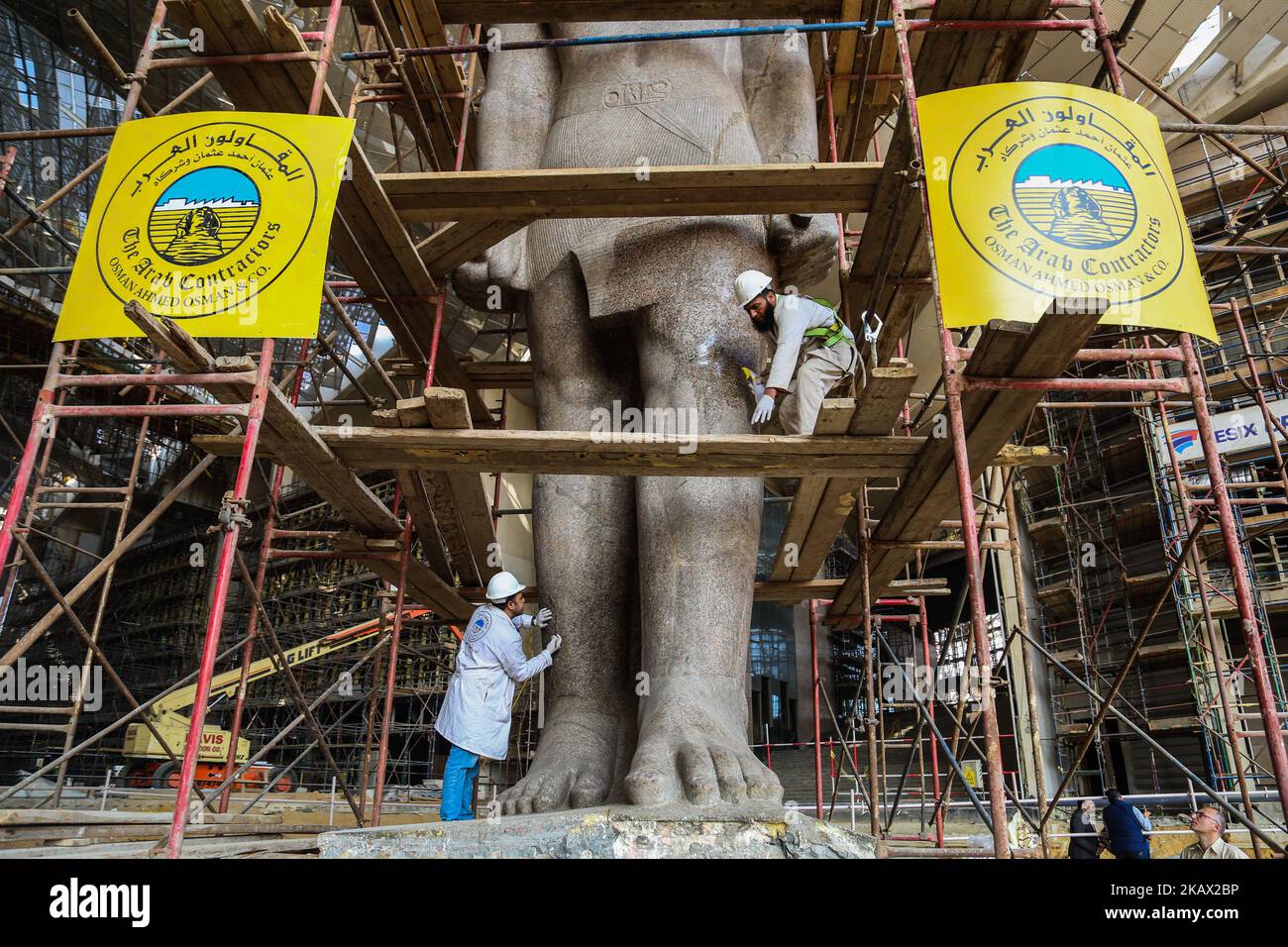 Egyptian workers restore a giant granite statue of the ancient Egyptian ...