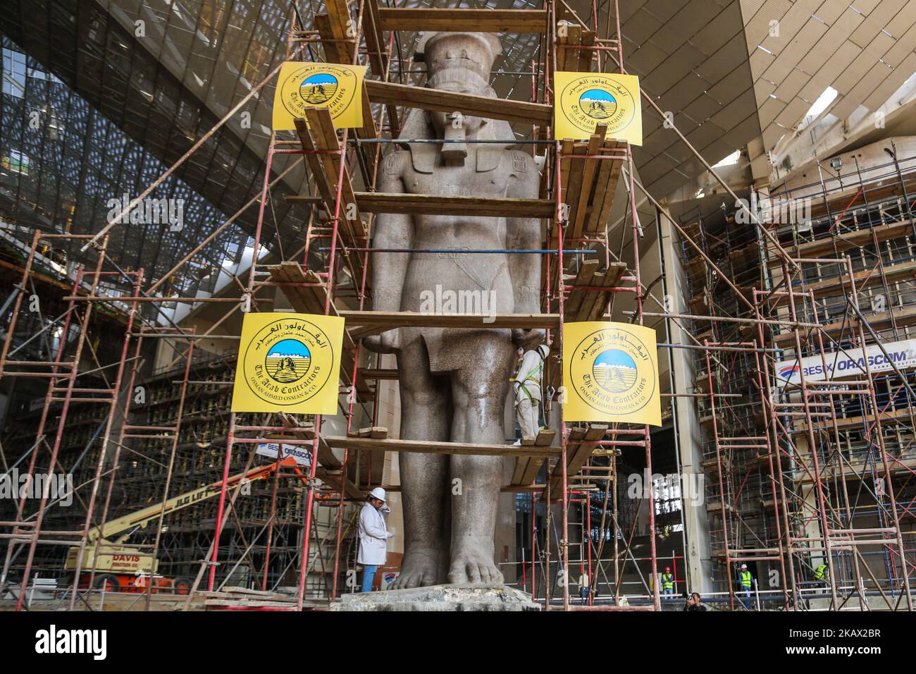 Egyptian workers restore a giant granite statue of the ancient Egyptian ...