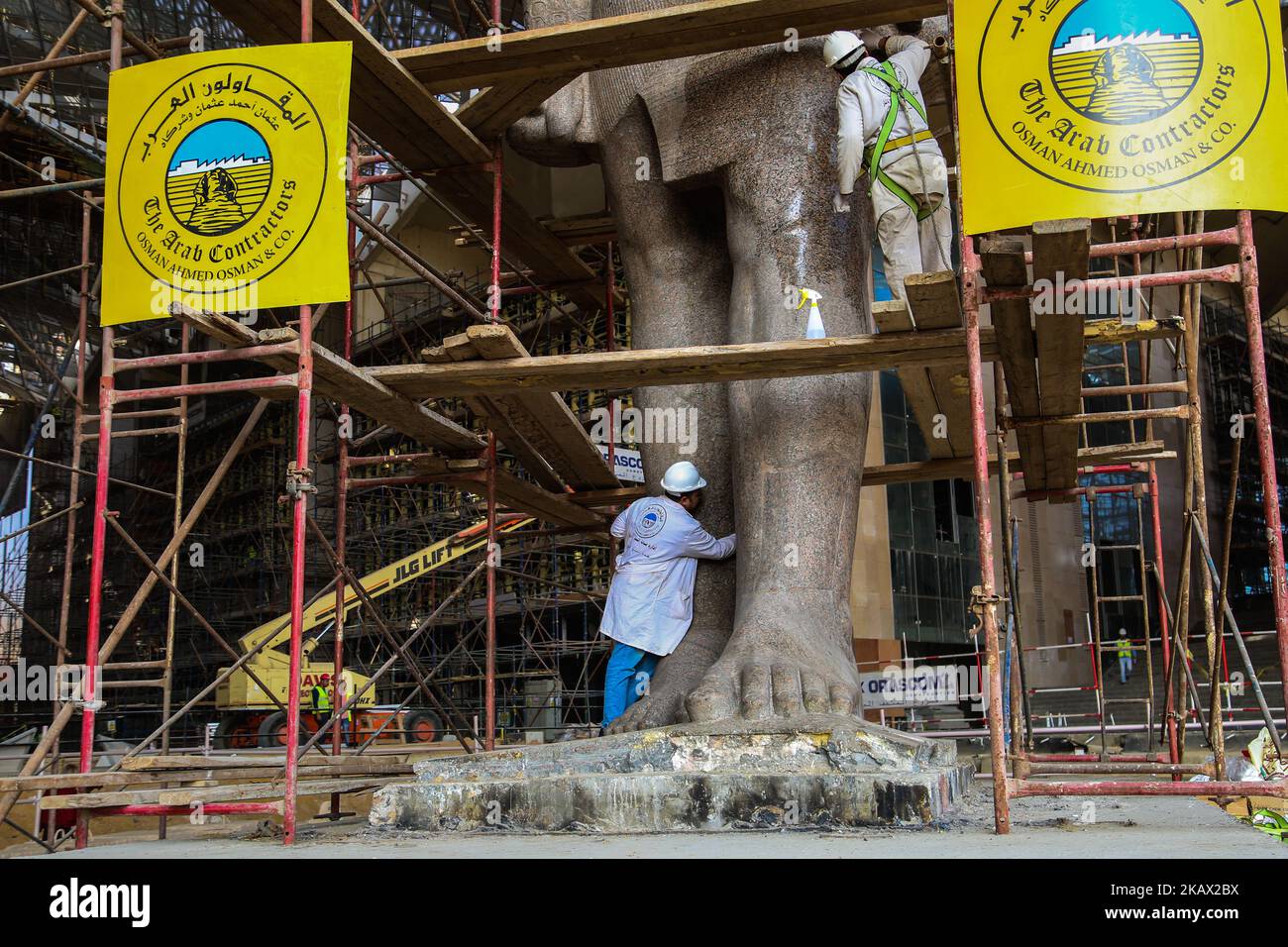 Egyptian workers restore a giant granite statue of the ancient Egyptian ...