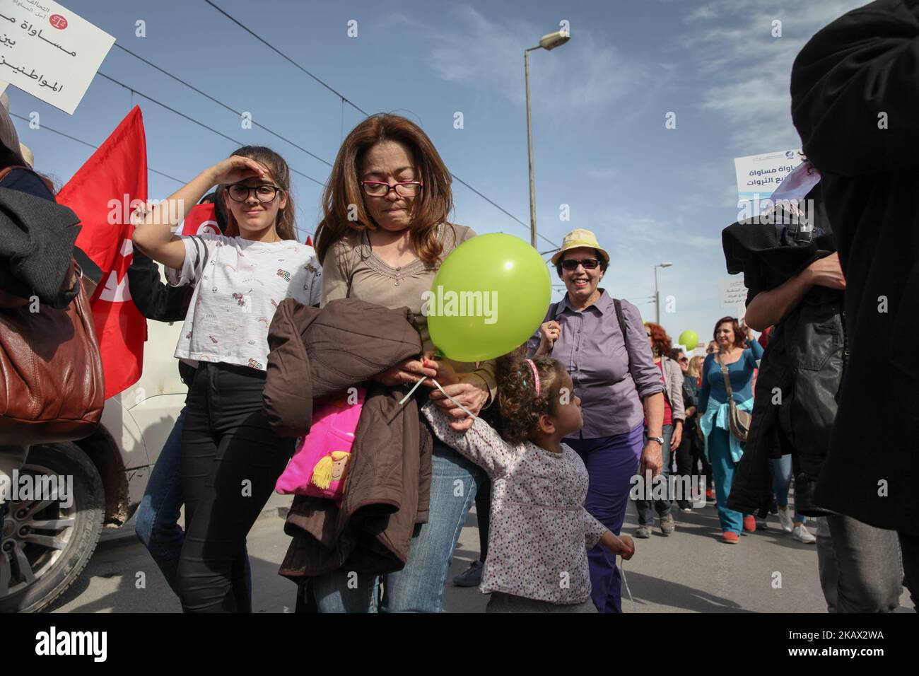 A little girl with her mother attend a march held in Tunis, Tunisia to ...