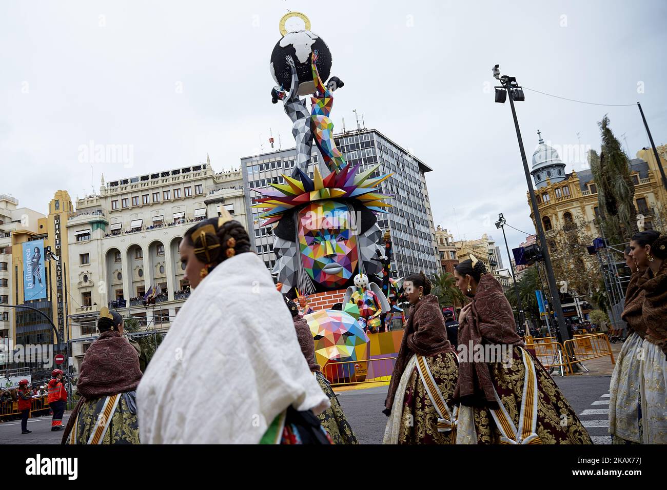 Falleras dressed up in traditional costume walk past a Falla during Las ...