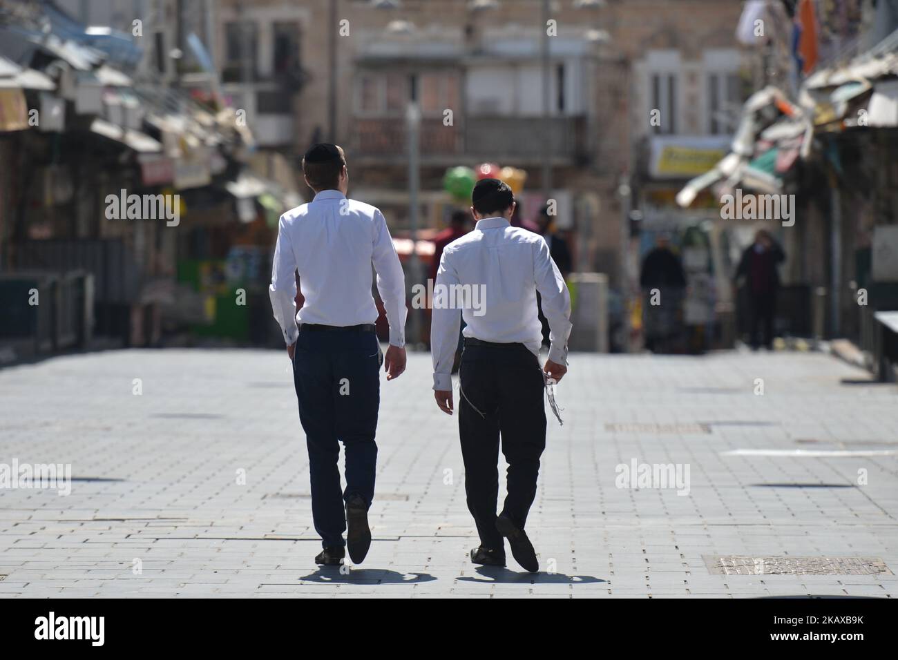 Two young jewish men walk through an empty Mahane Yehuda market in ...