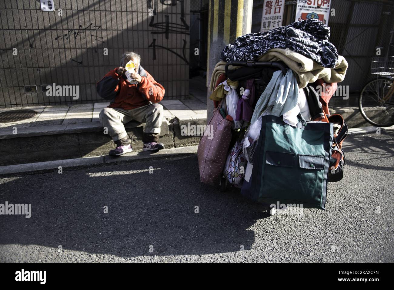 OSAKA, JAPAN - MARCH 31: A homeless man eats in the street of Airin in ...