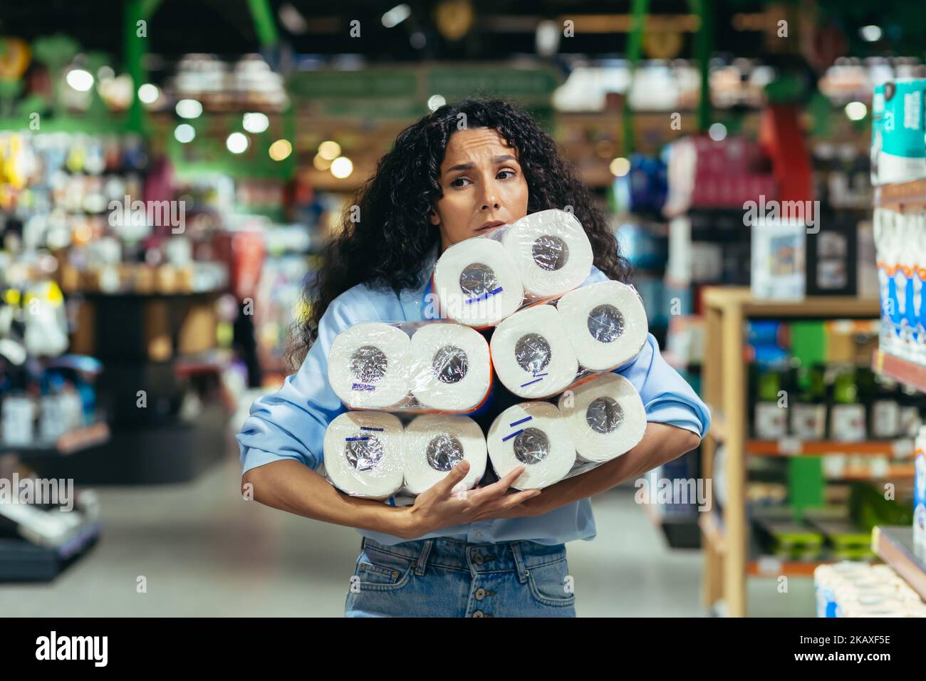 Frightened woman shopper in supermarket buys toilet paper, Latin ...