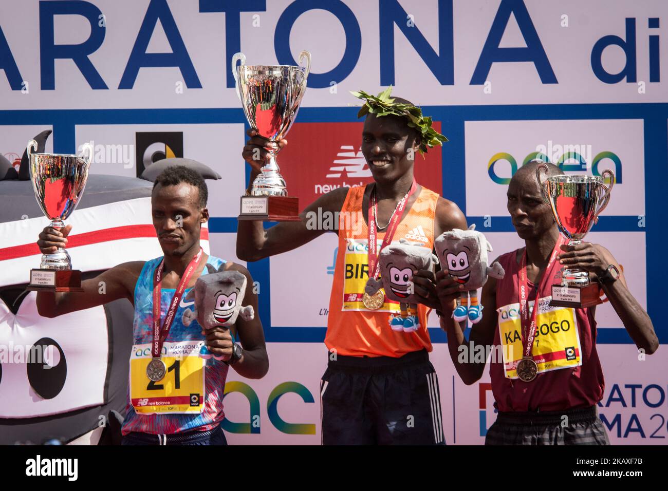 Kenya's Jairus Kipchoge Birech (C) celebrates on the podium next to ...