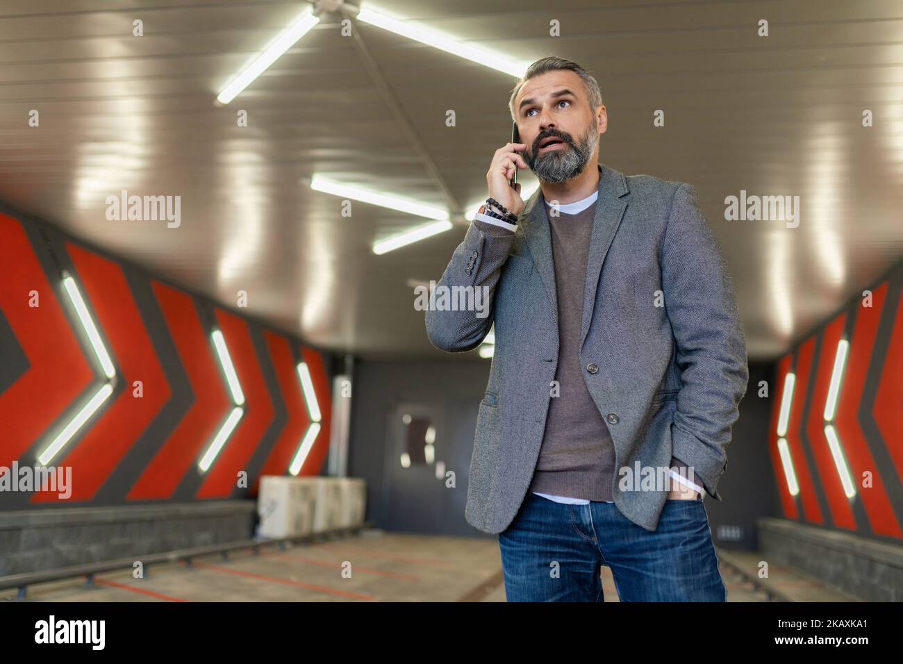 fifty-year-old Caucasian man speaks on a mobile phone in an underground ...