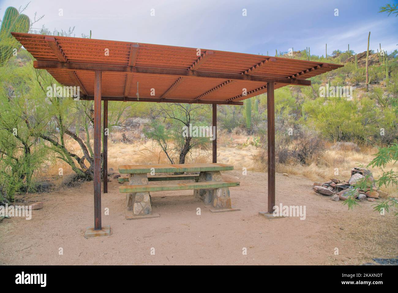 Concrete dining table with seats under the rusty metal pergola roof at ...