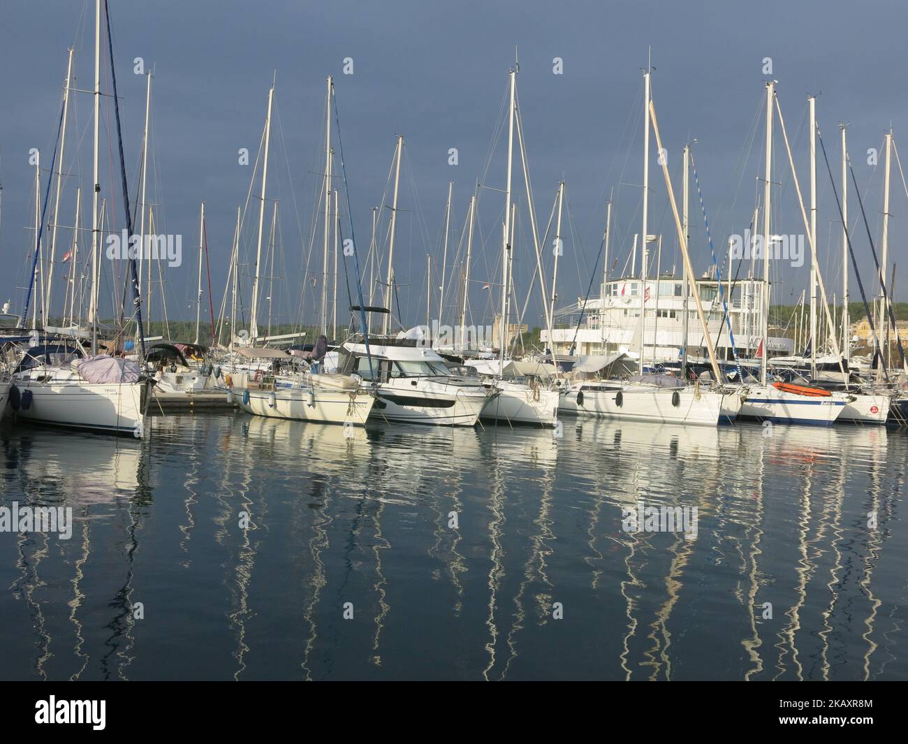 Istria: tall masts of the yachts reflect in the clear waters of Pula ...