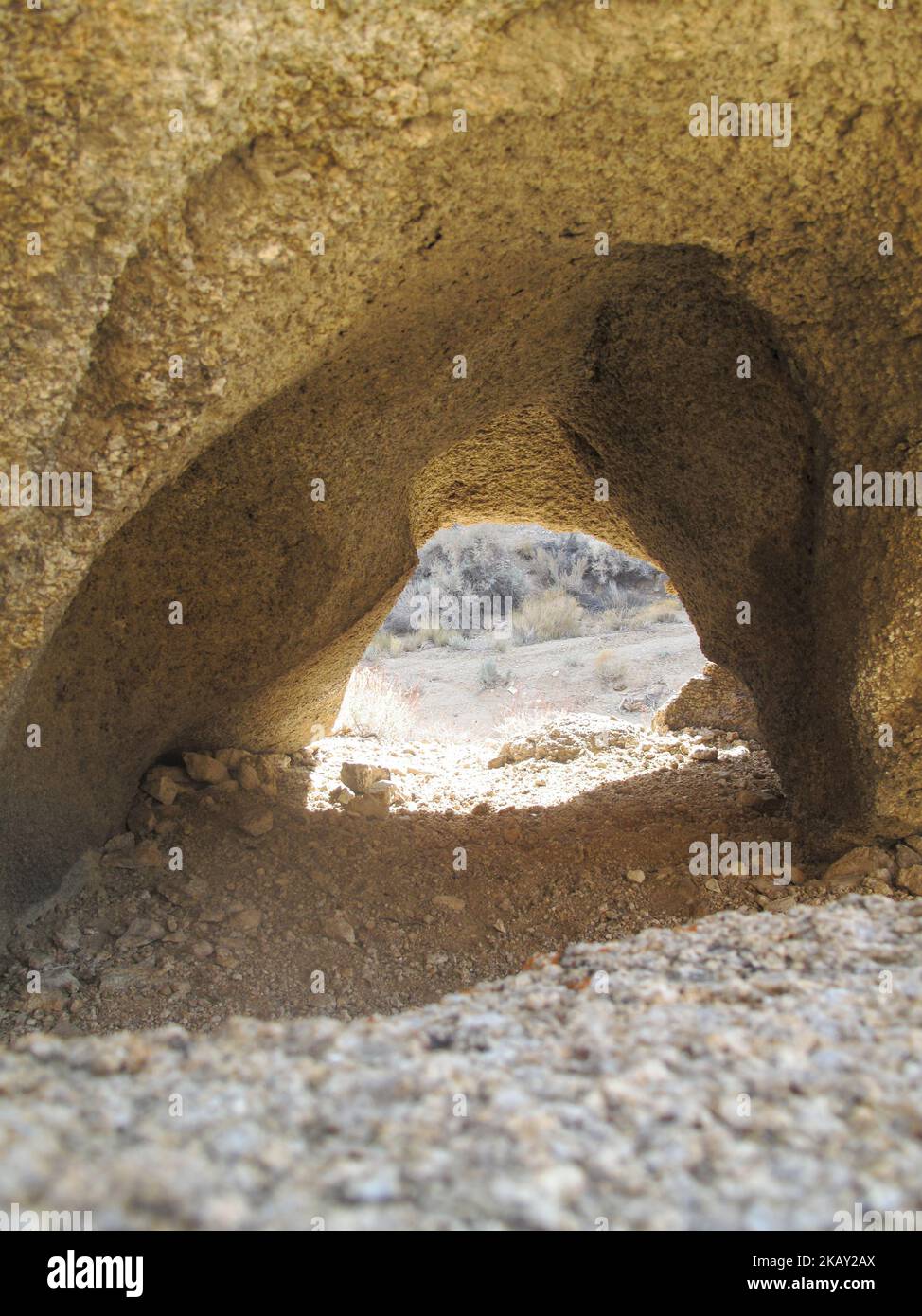 A vertical shot of a small cave oppening on slope of death valley ...