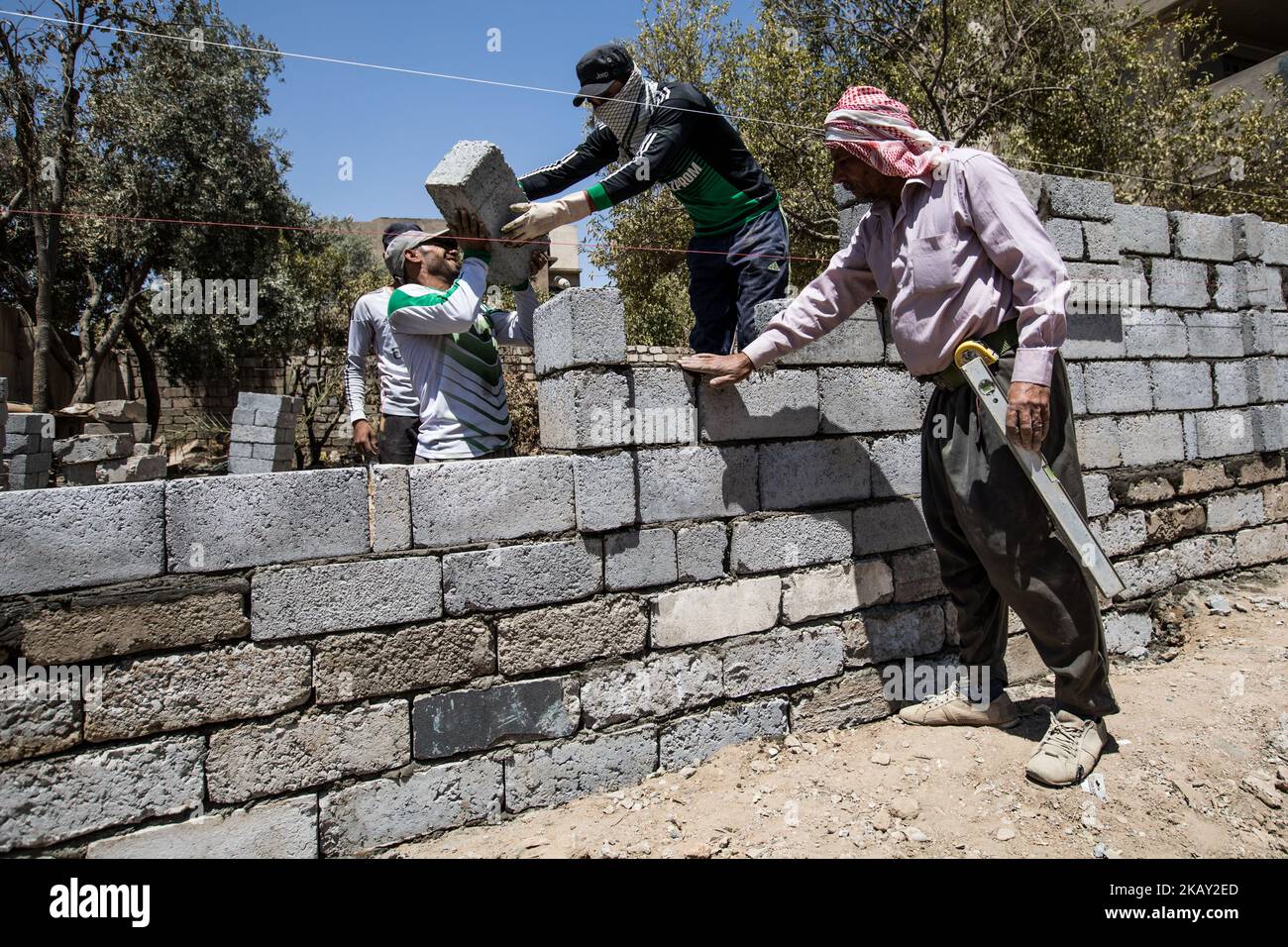 (7/11/2017) Residents of West Mosul / Iraq rebuild a wall that was ...