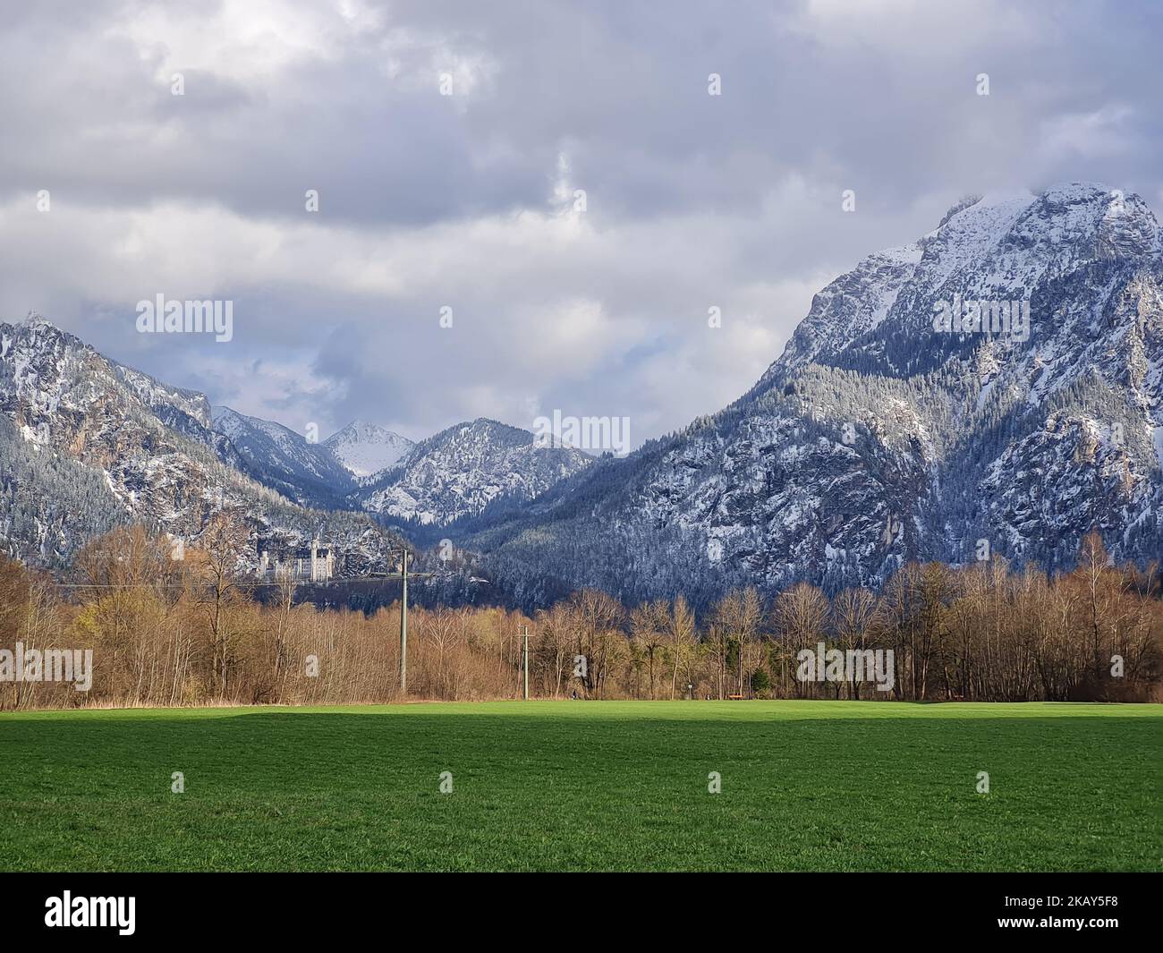 An aerial view of a green clearing near the snowy Allgauer Alps in ...