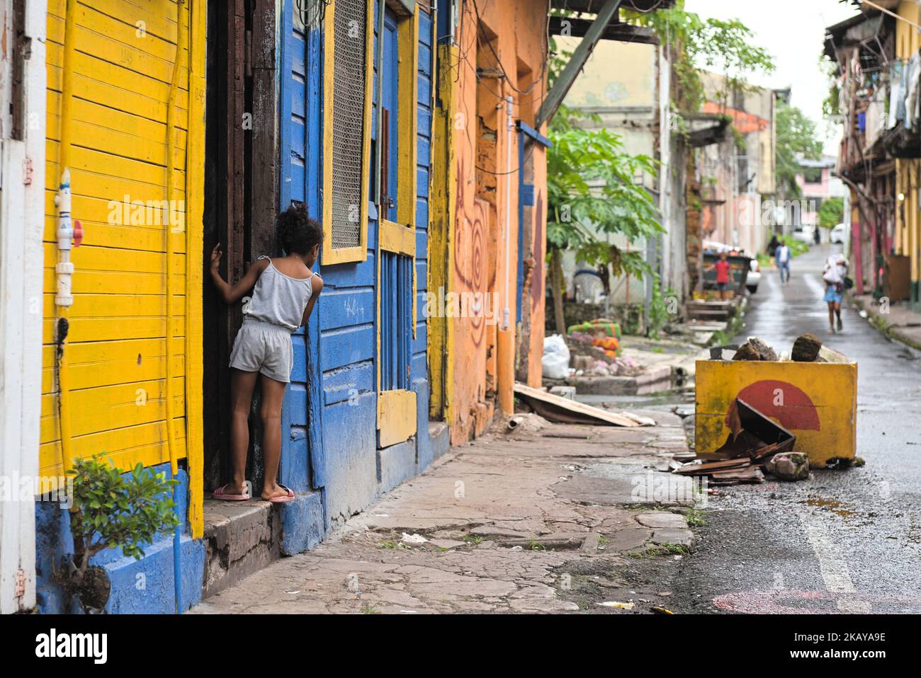 Curious girl in a colorful street, looking at toher people, in the ...