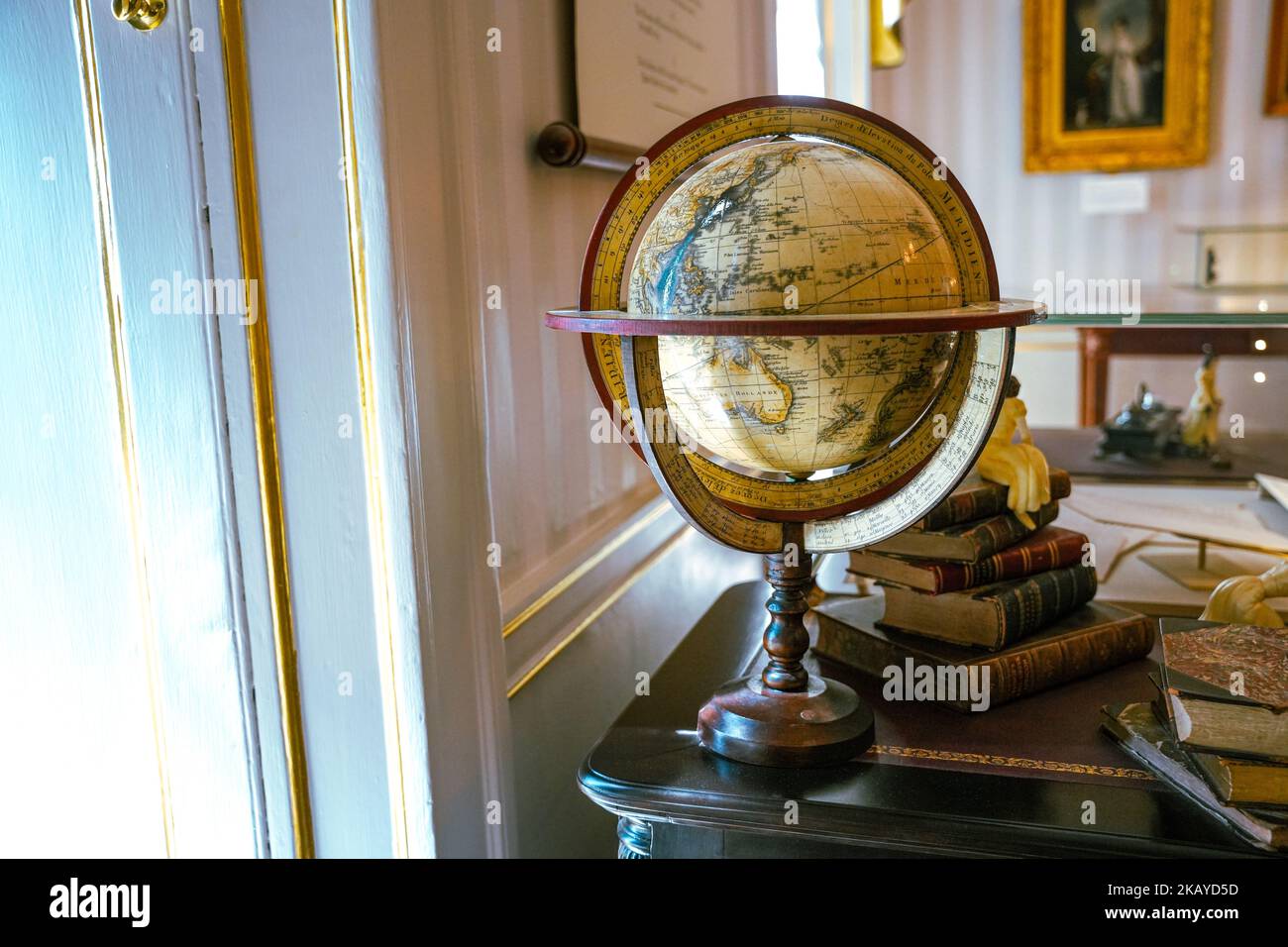 A vintage globe and books in a room Stock Photo - Alamy