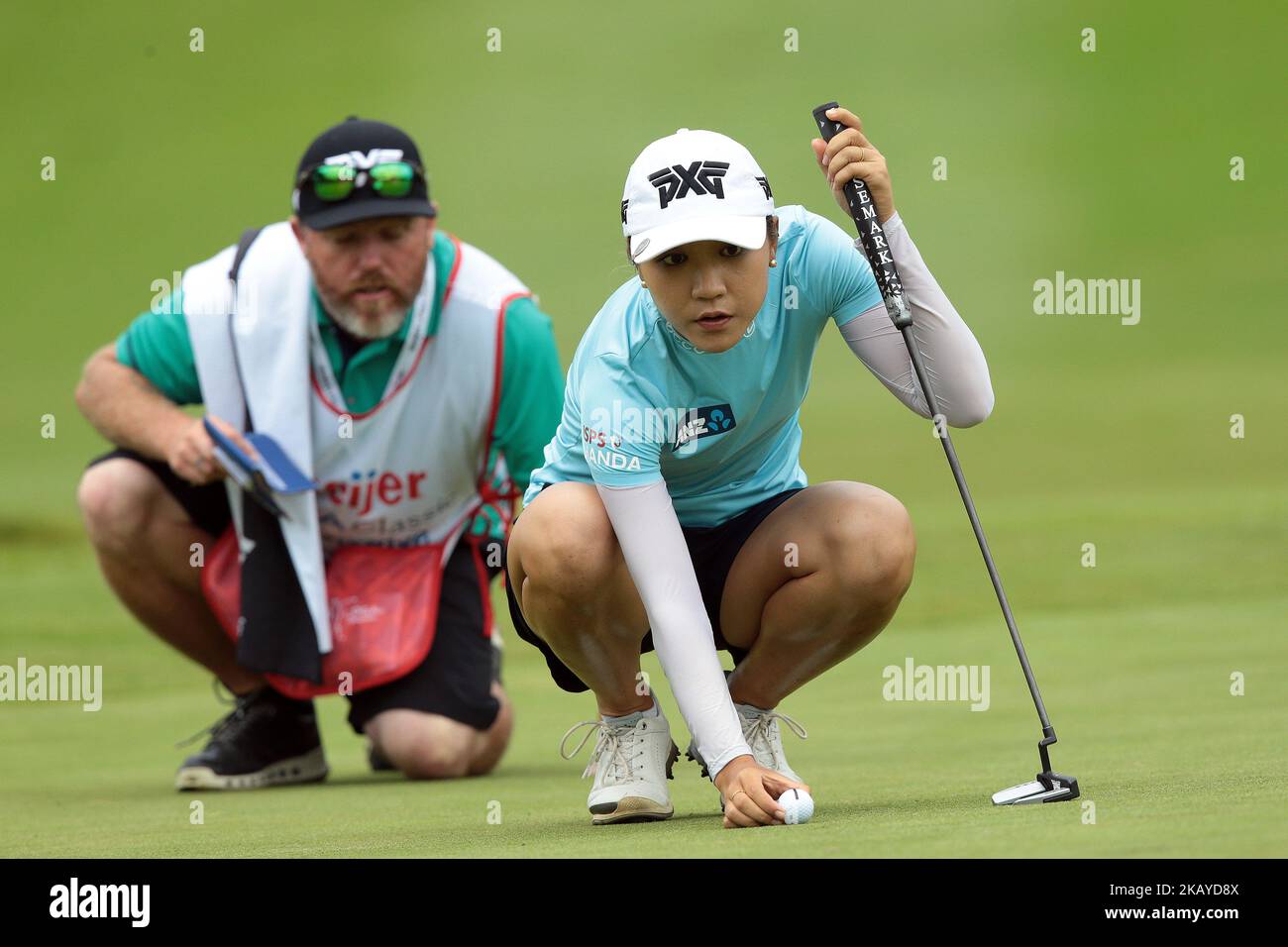 Lydia Ko of New Zealand lines up her putt on the first green during the ...