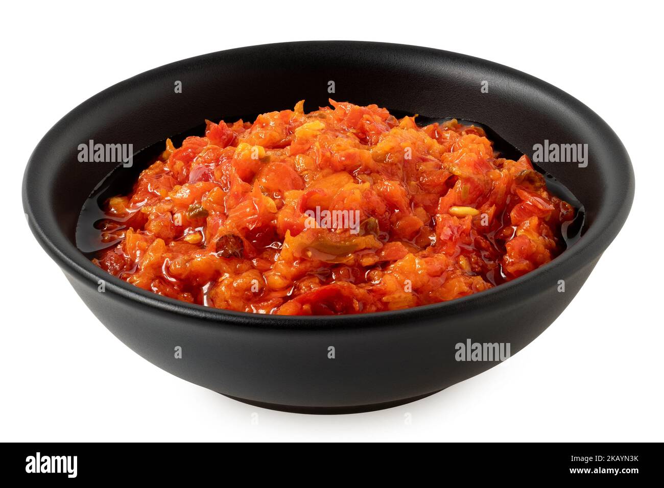 Chopped red chilli peppers in olive oil in black ceramic bowl isolated ...