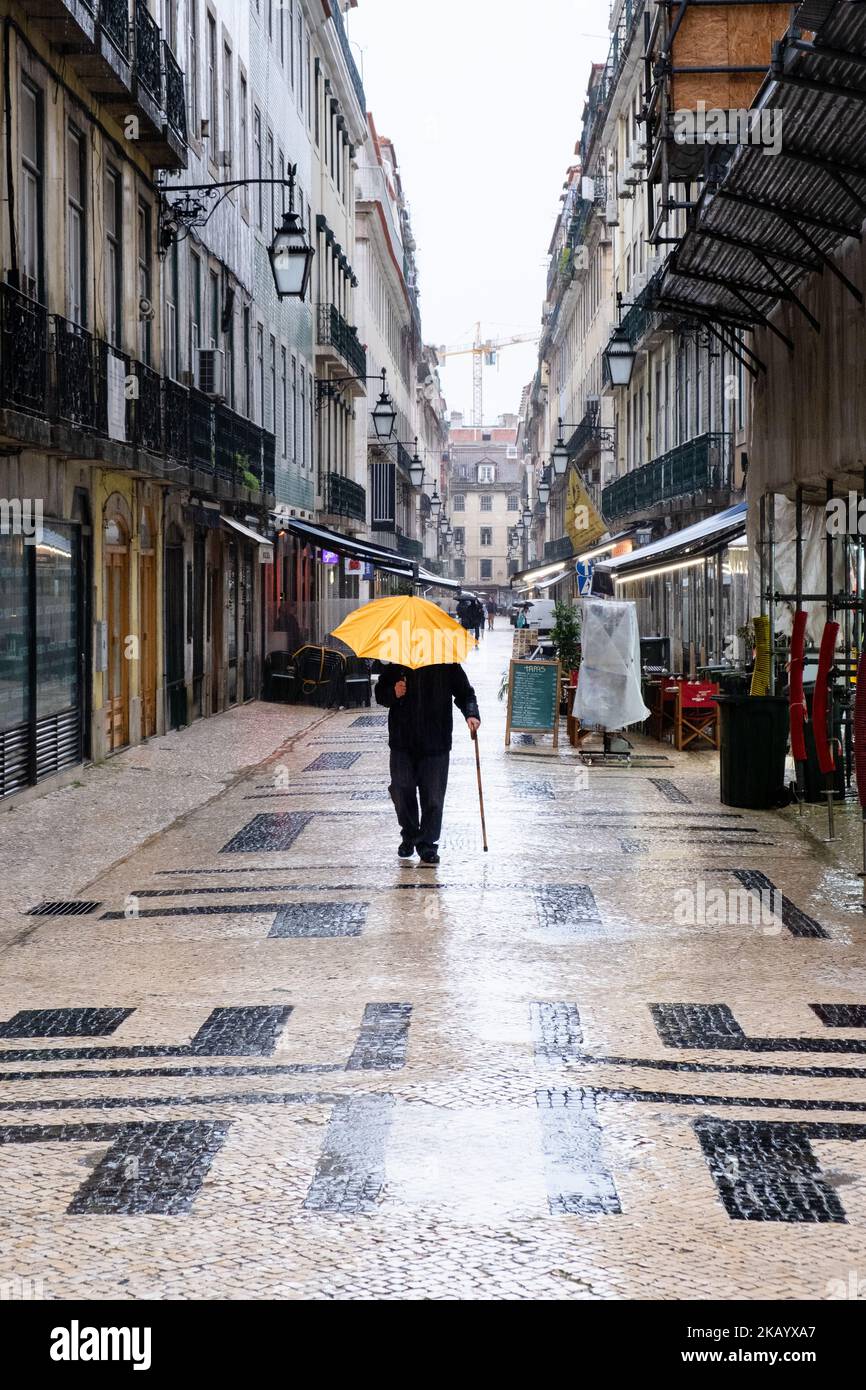 OLD MAN, YELLOW UMBRELLA, RAINSTORM, LISBON: Heavy rain in the centre ...