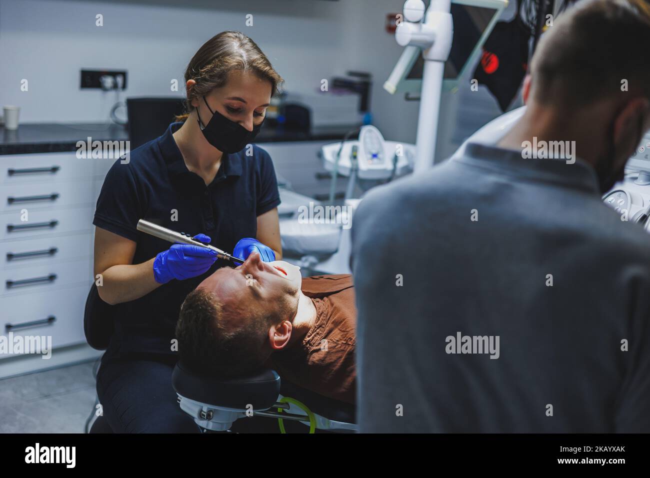 Dental treatment of teeth. A young man at a dentist's appointment. A ...