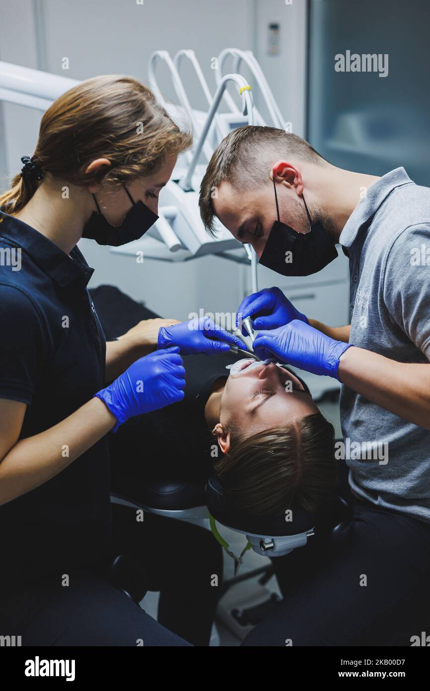 Orthodontic treatment of teeth. The doctor installs metal braces on the ...