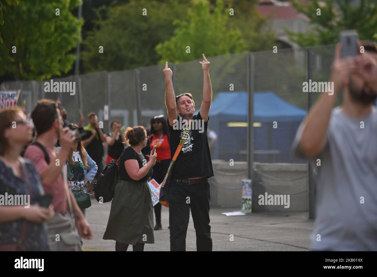 A demonstrators shows his middle fingers as the Marine One leaves ...