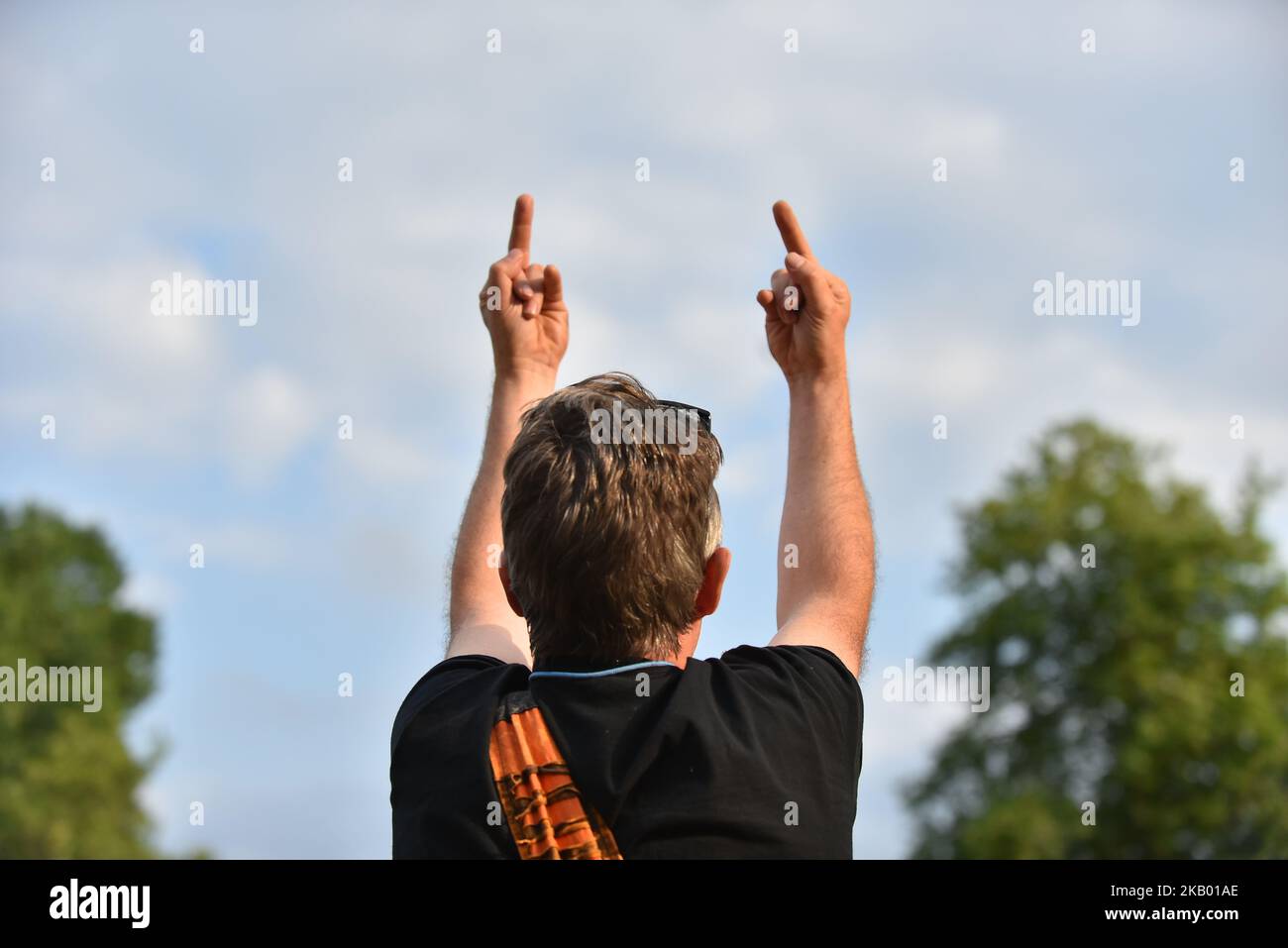 A demonstrators shows his middle fingers as the Marine One leaves ...