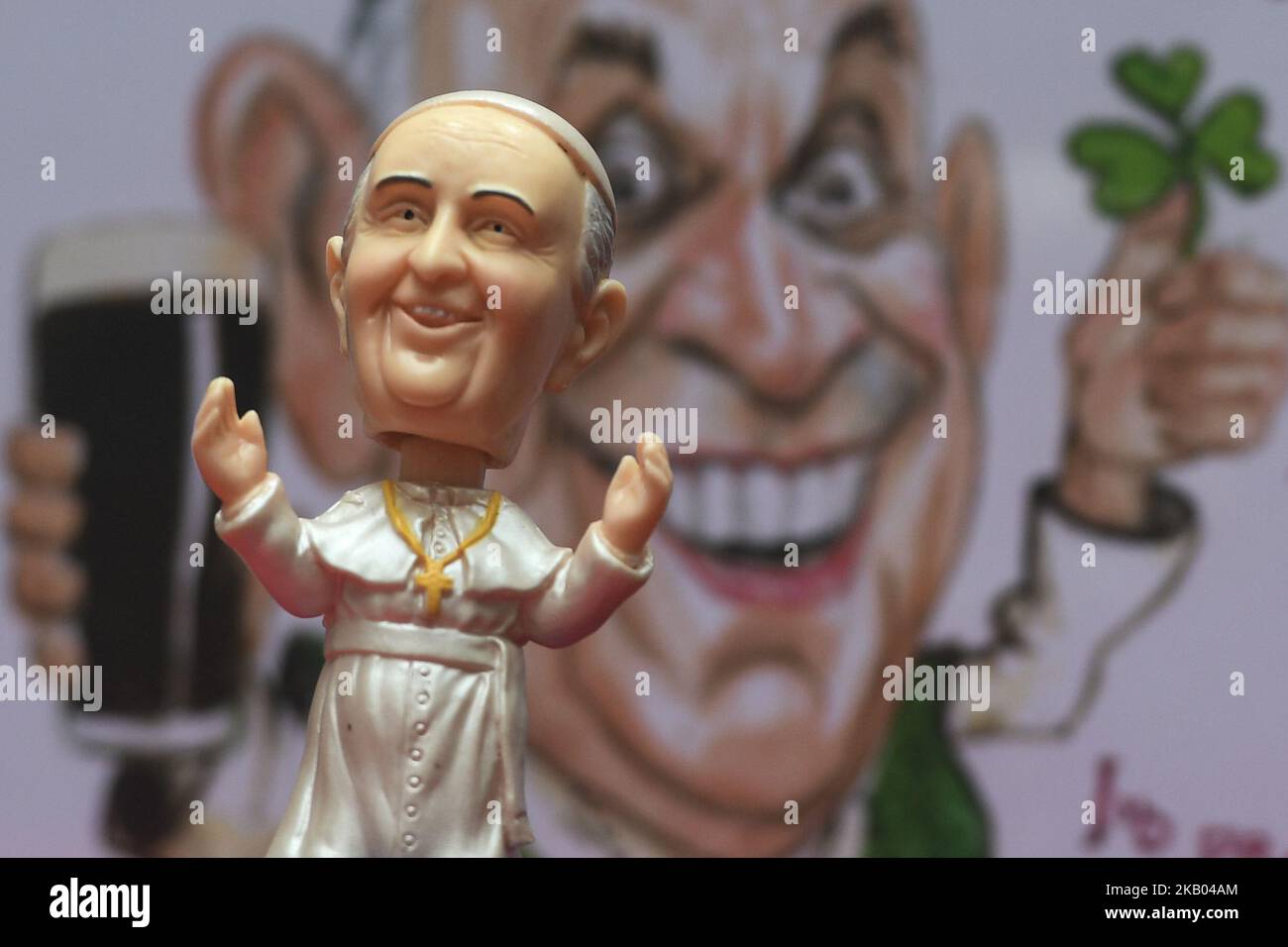 A mini size Pope Francis Bobble head in front of a watercolor ...