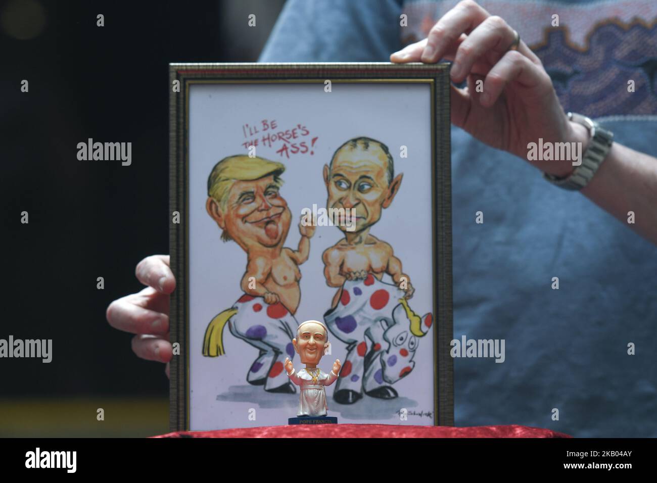 A mini size Pope Francis Bobble head in front of a watercolor ...