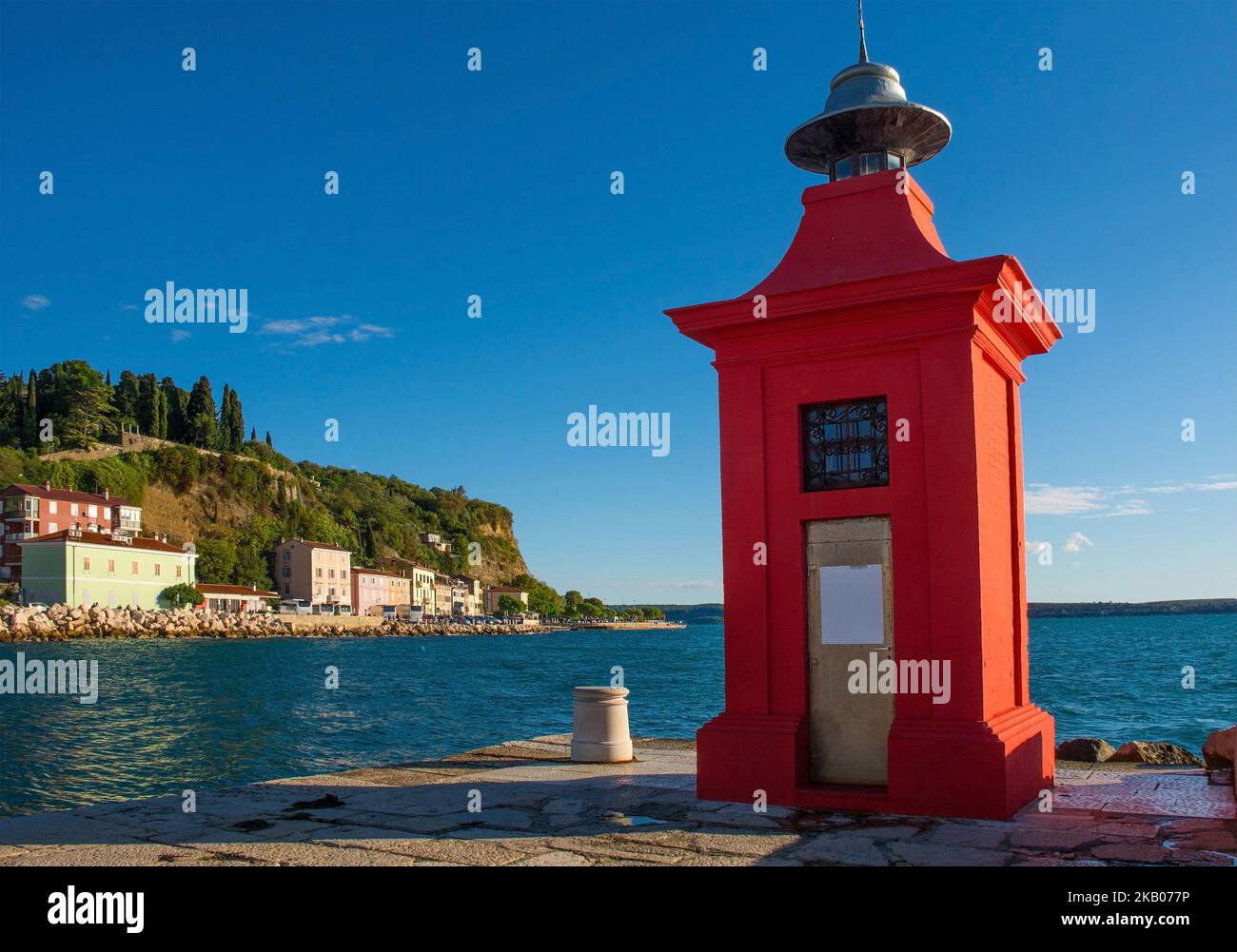 A red lighthouse on the waterfront of the historic medieval town of ...